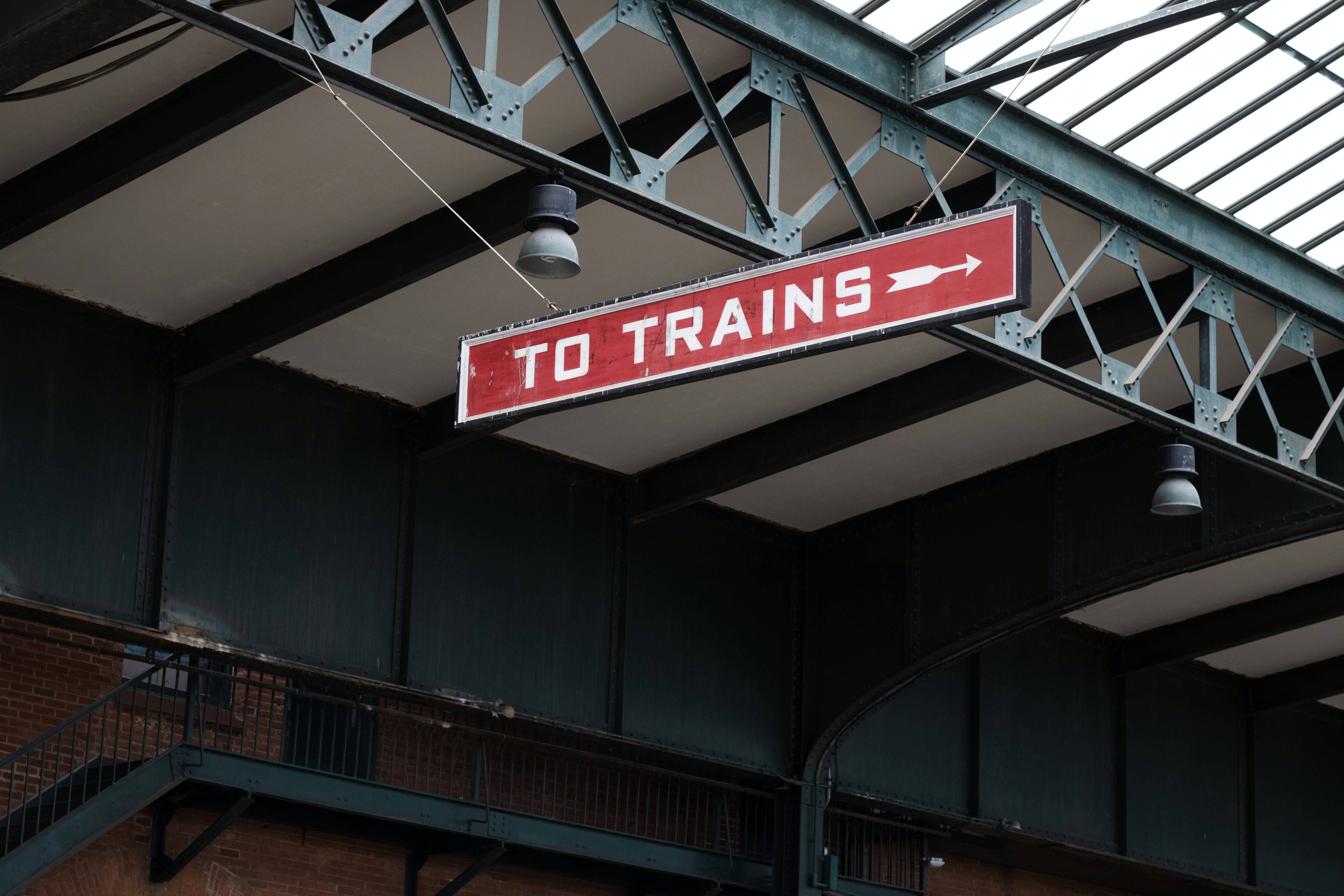 A red sign hanging from the ceiling of a train station photo – Free ...