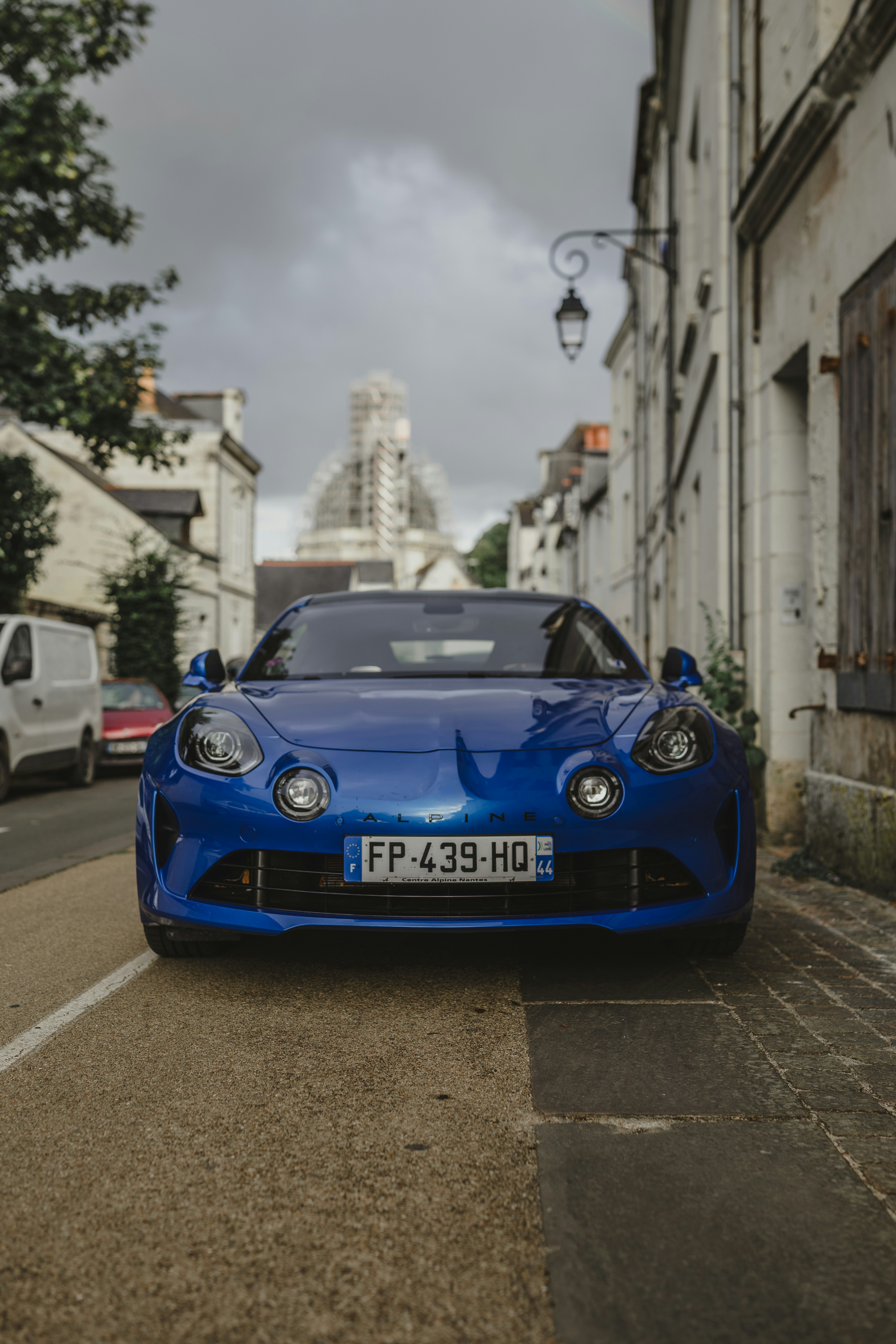 Cobalt Frontline: A Blue Sports Car on a Cobblestone Lane