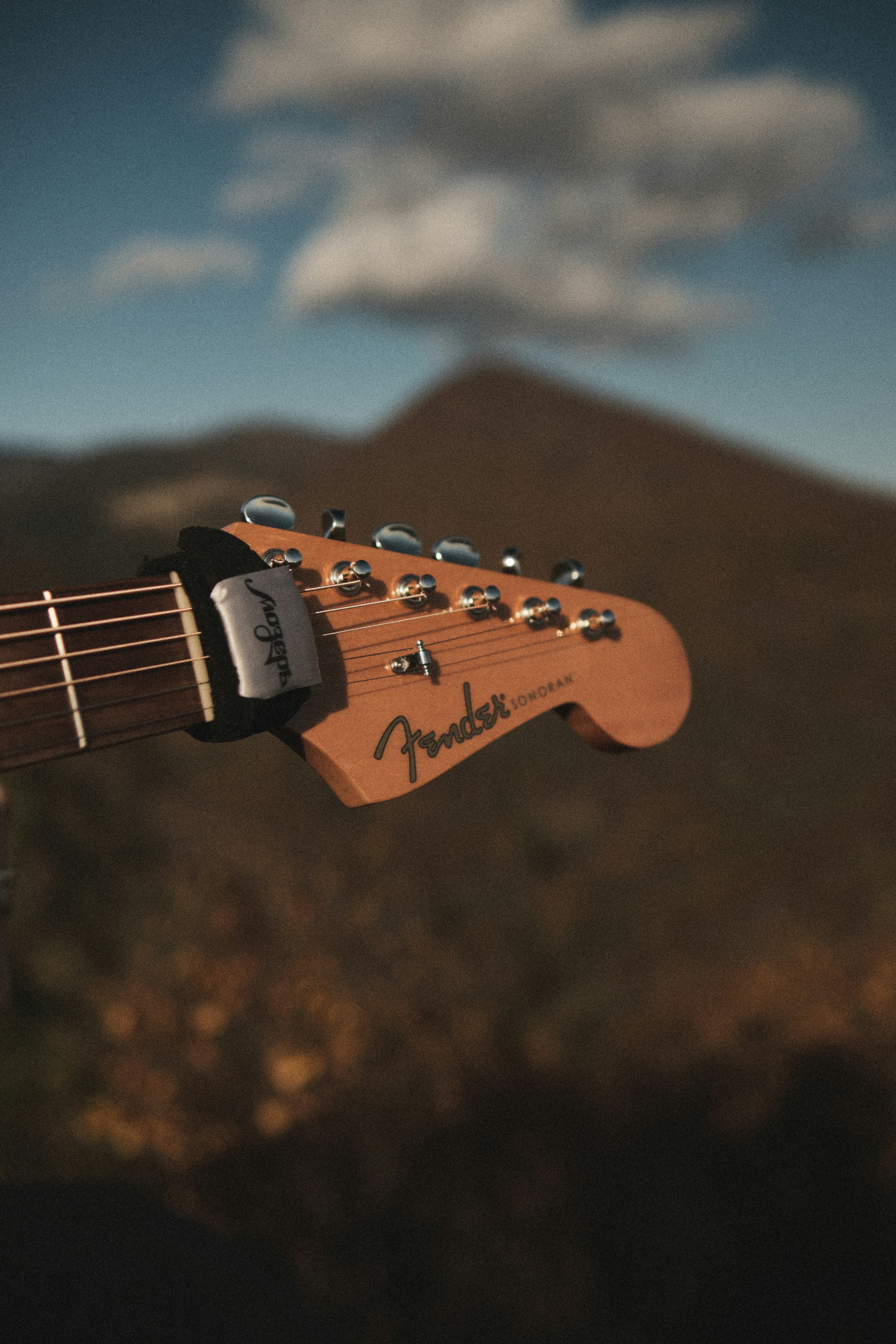 Sunlit Fender Headstock Framed by Echoing Peaks