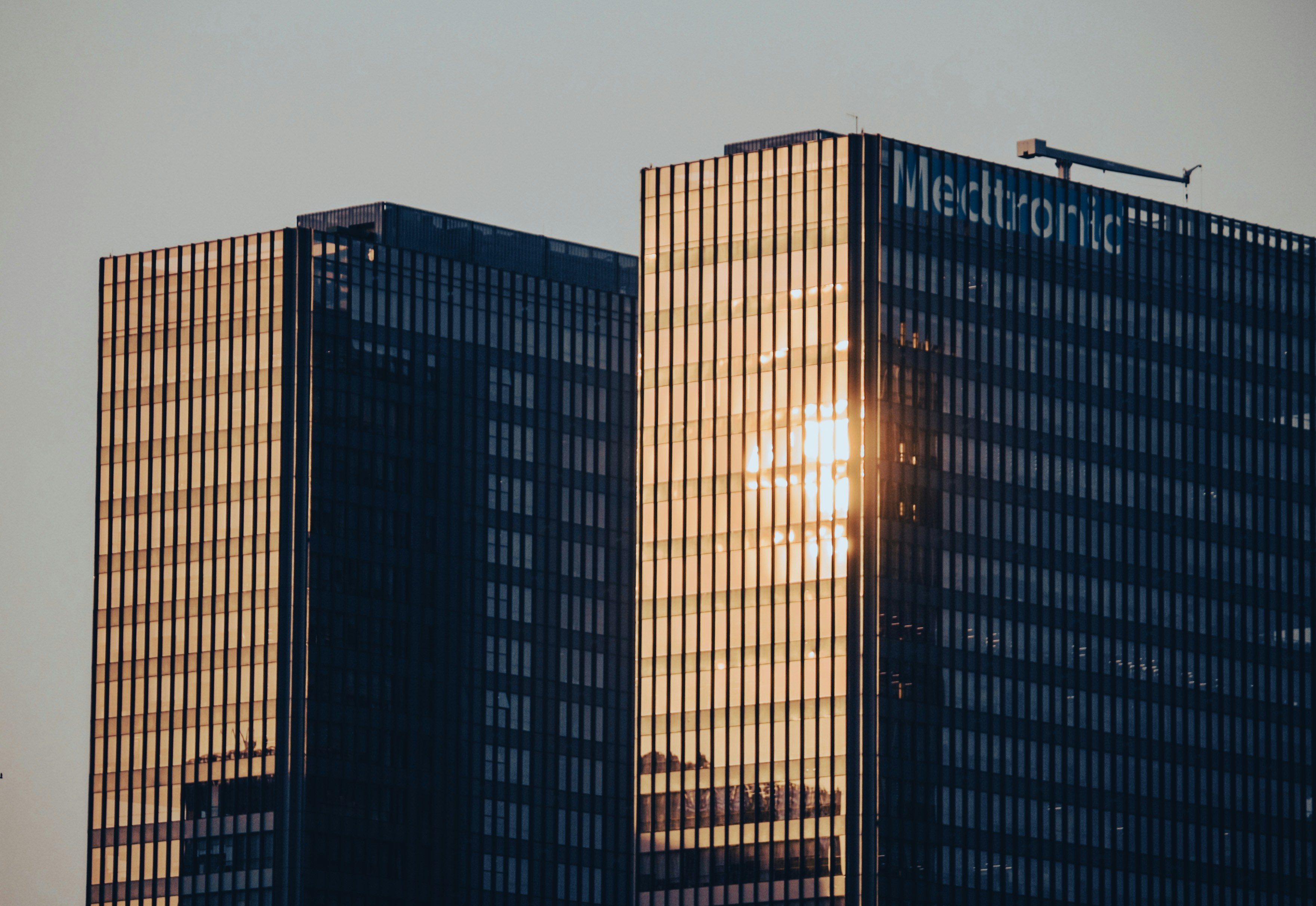 Sunlight reflecting on glass skyscrapers, creating a warm glow against a clear sky.