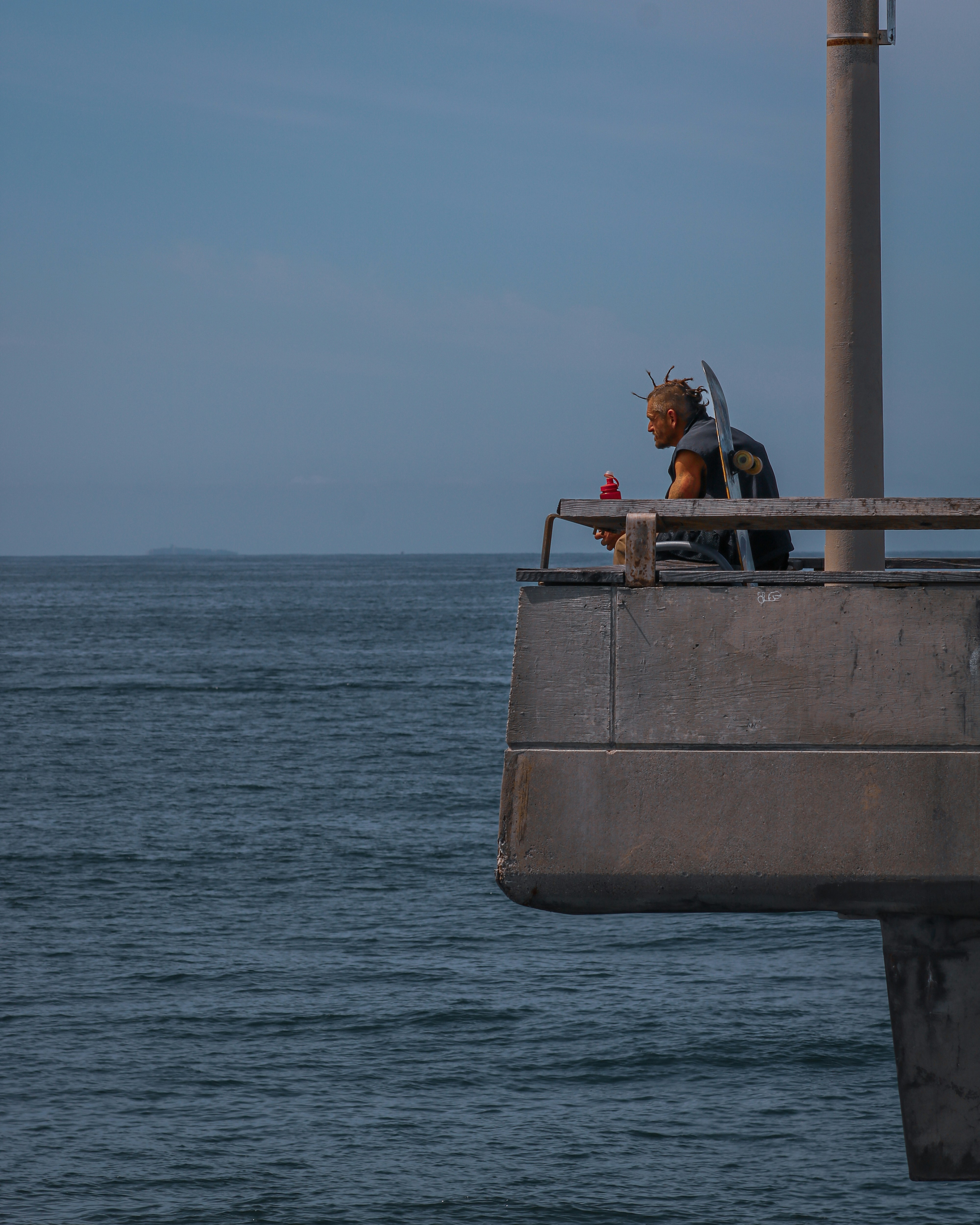 Seaside Sentinel: A lone observer on a concrete balcony over the horizon