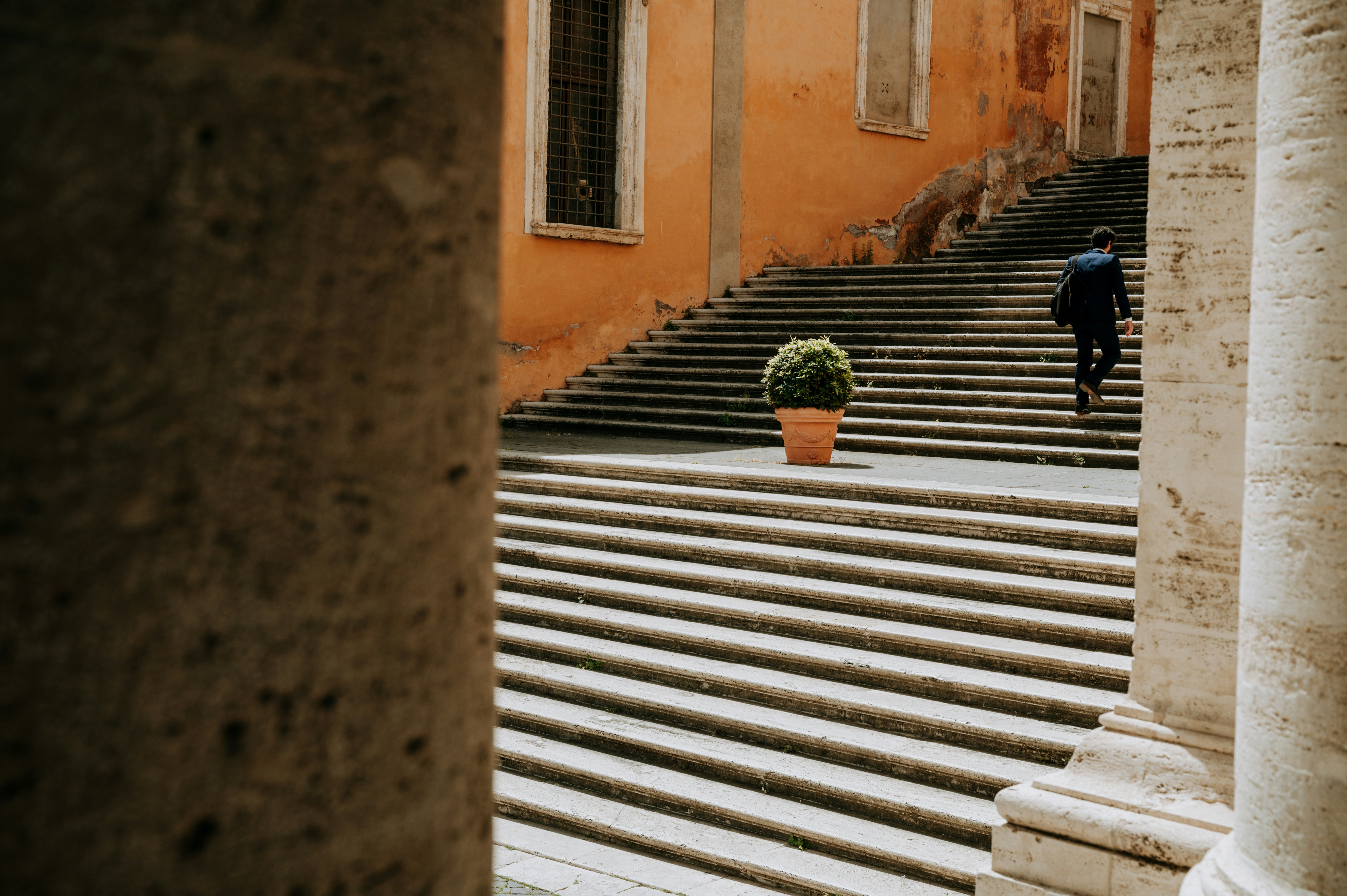 A man walking down a set of steps next to a building photo – Free Brown ...