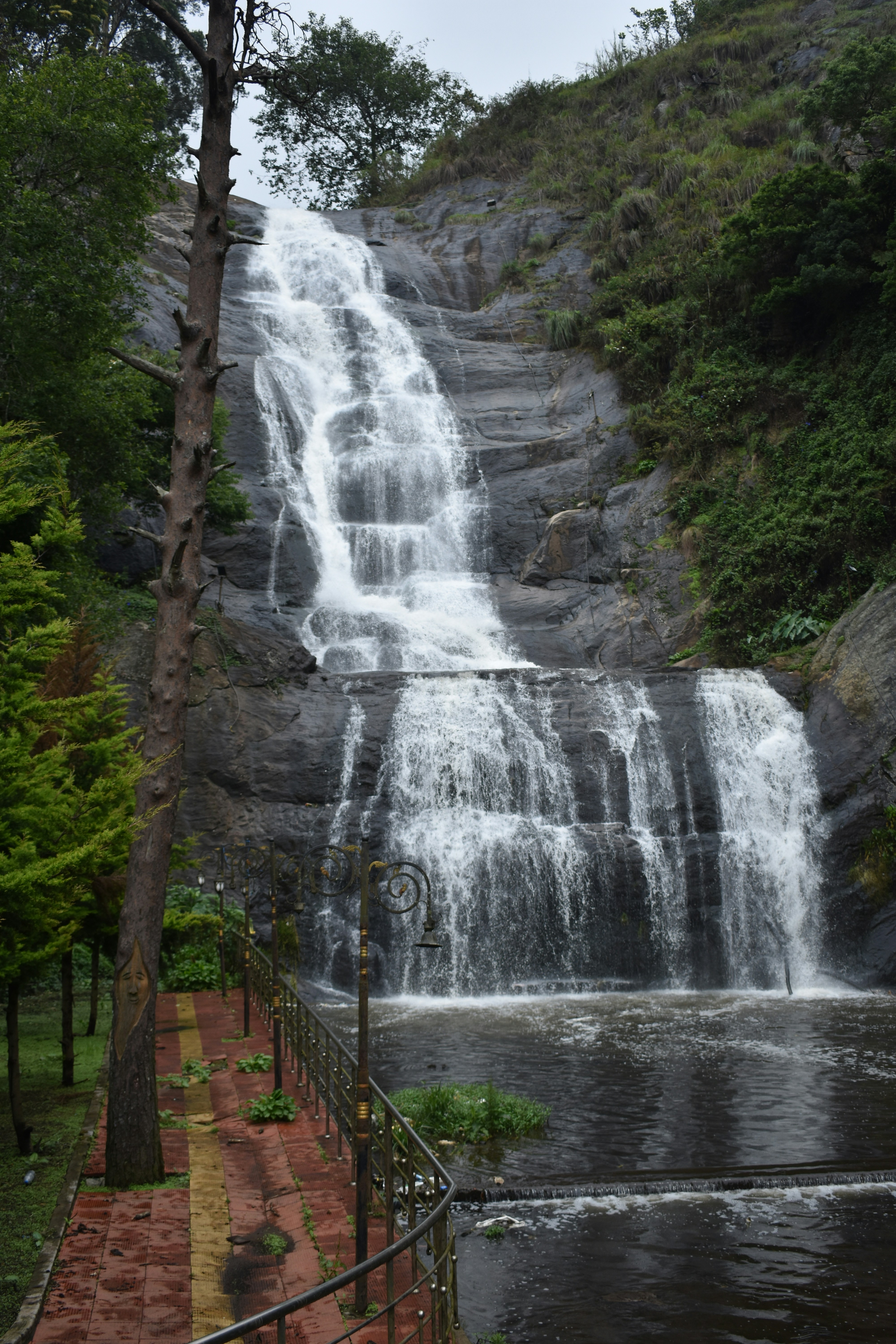 Whispering Tiers: Waterfall Cascades Along a Park Path