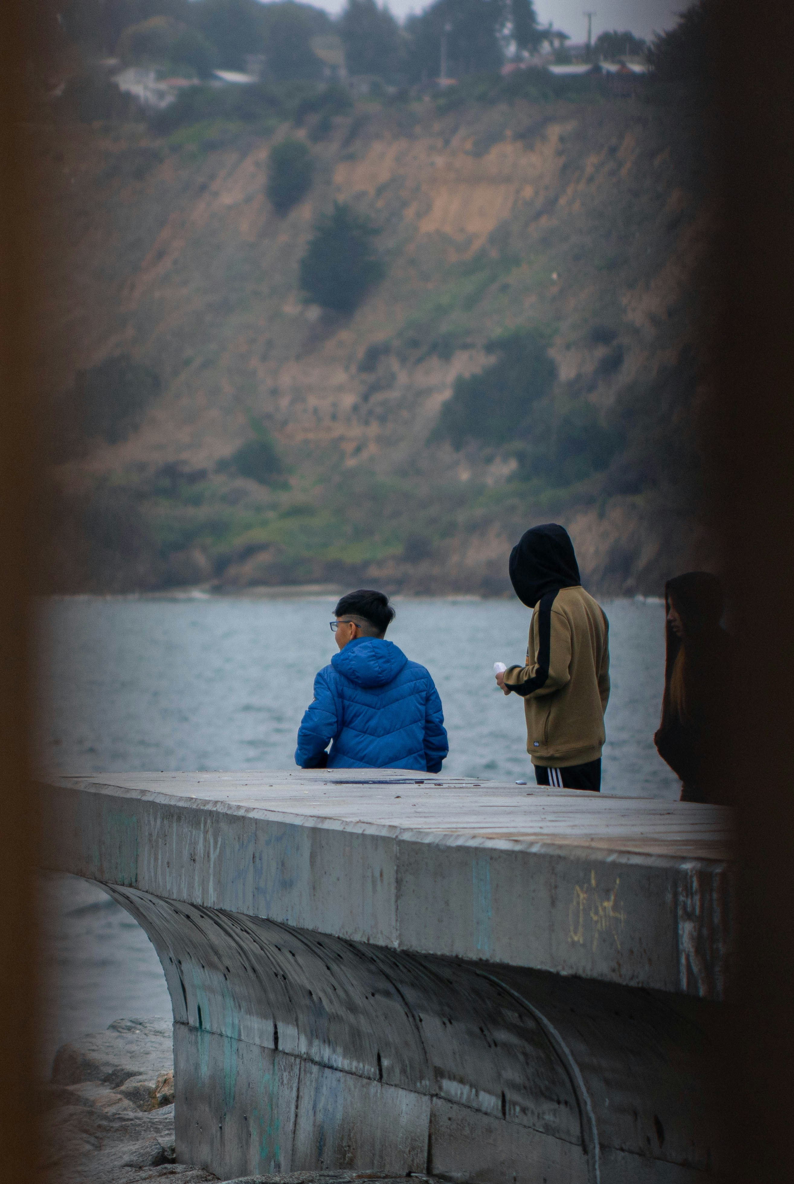 A couple of people sitting on top of a pier
