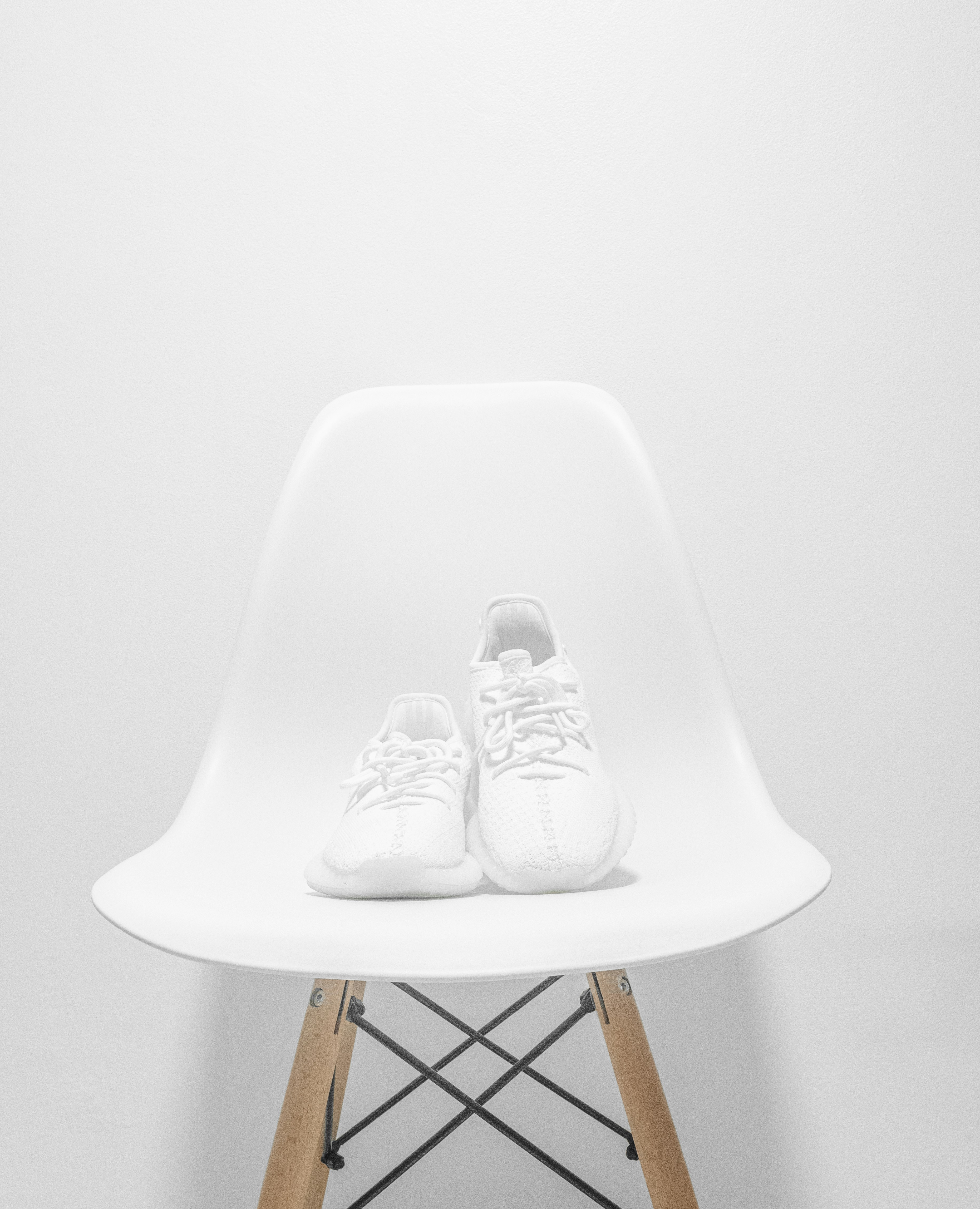 High-Key Minimalism: Two White Sneakers on a Molded Chair