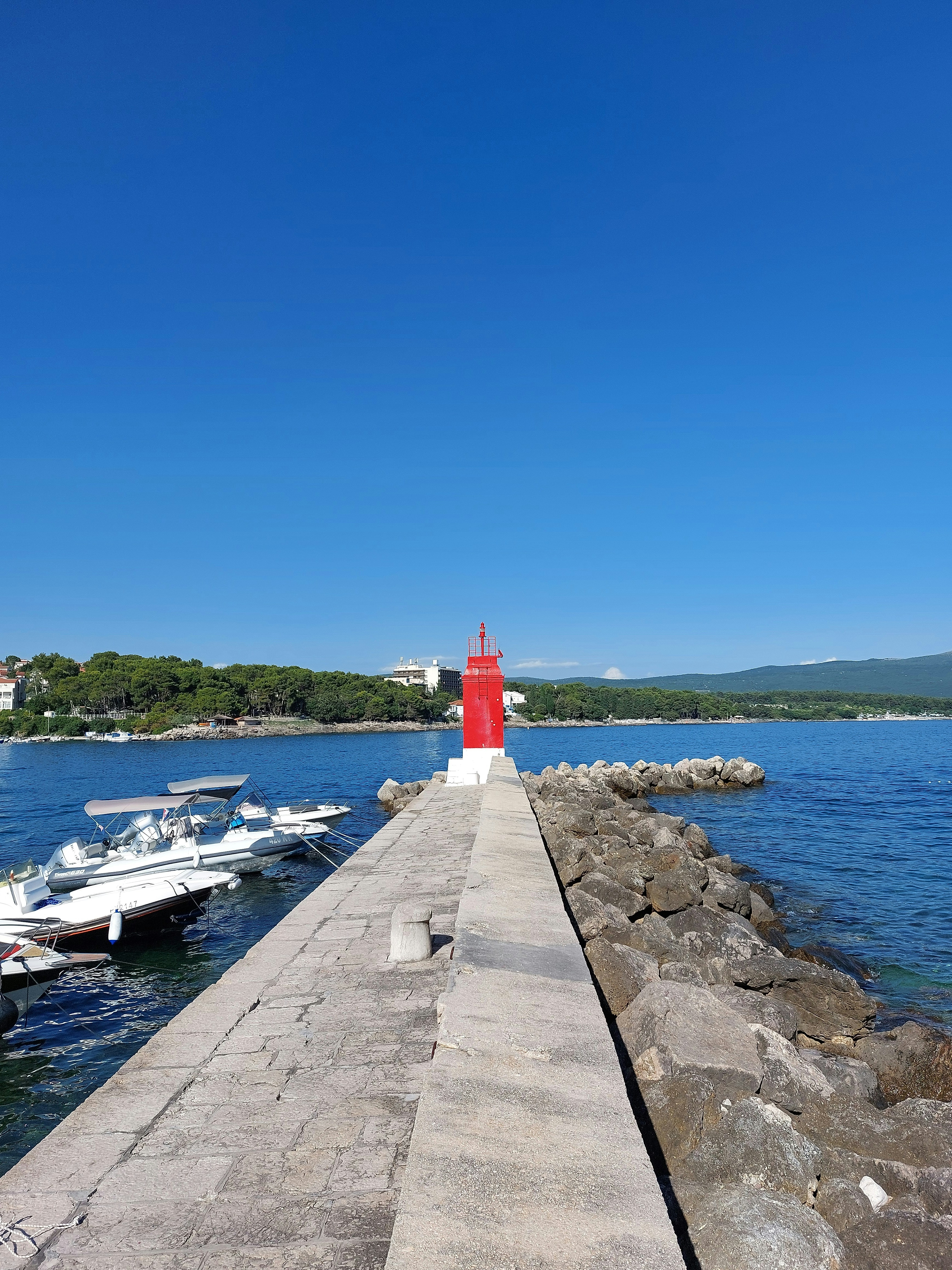 A red light house sitting on the end of a pier photo – Free Croatia ...