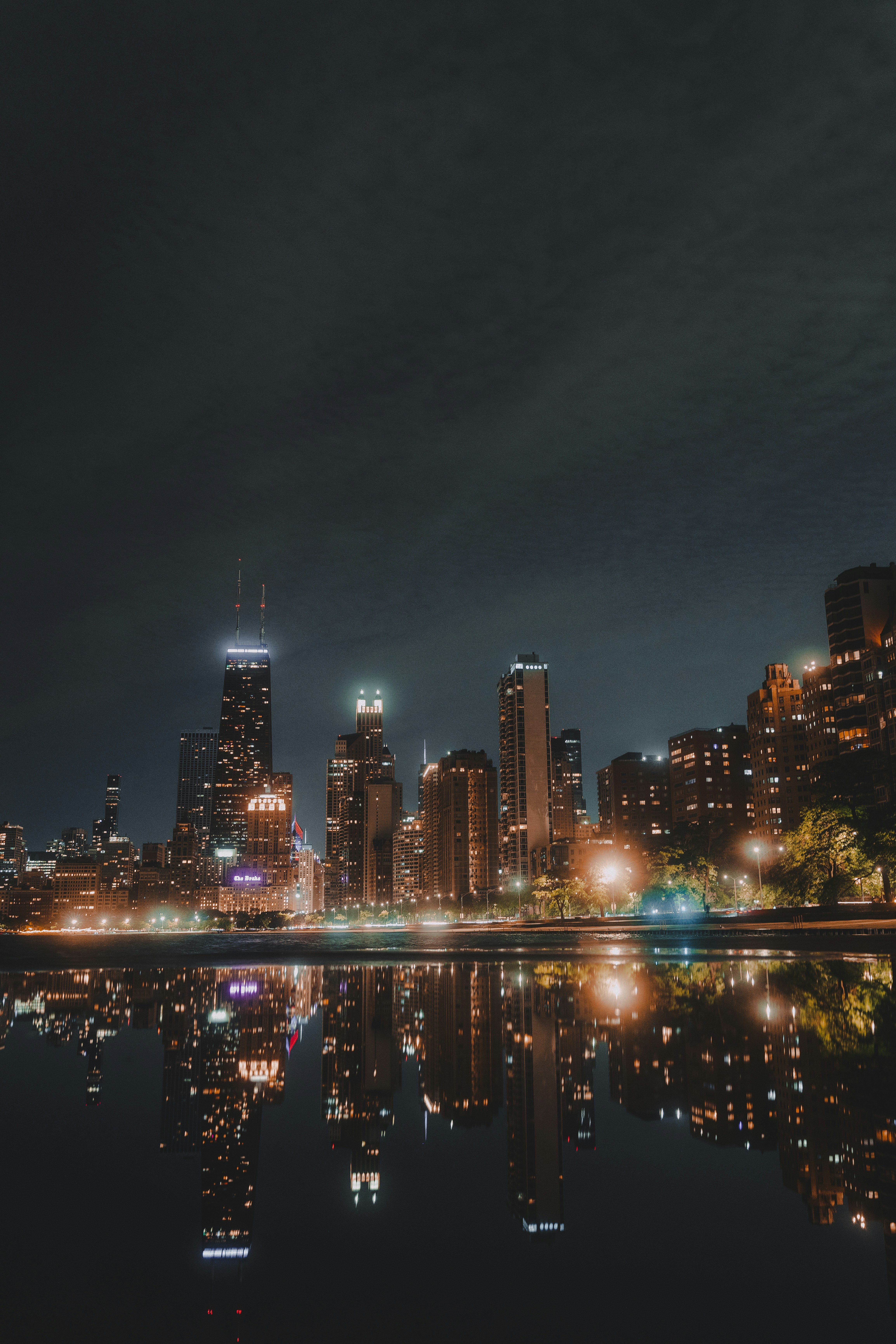 A city skyline at night with lights reflecting in the water photo – Free Chicago Image on Unsplash