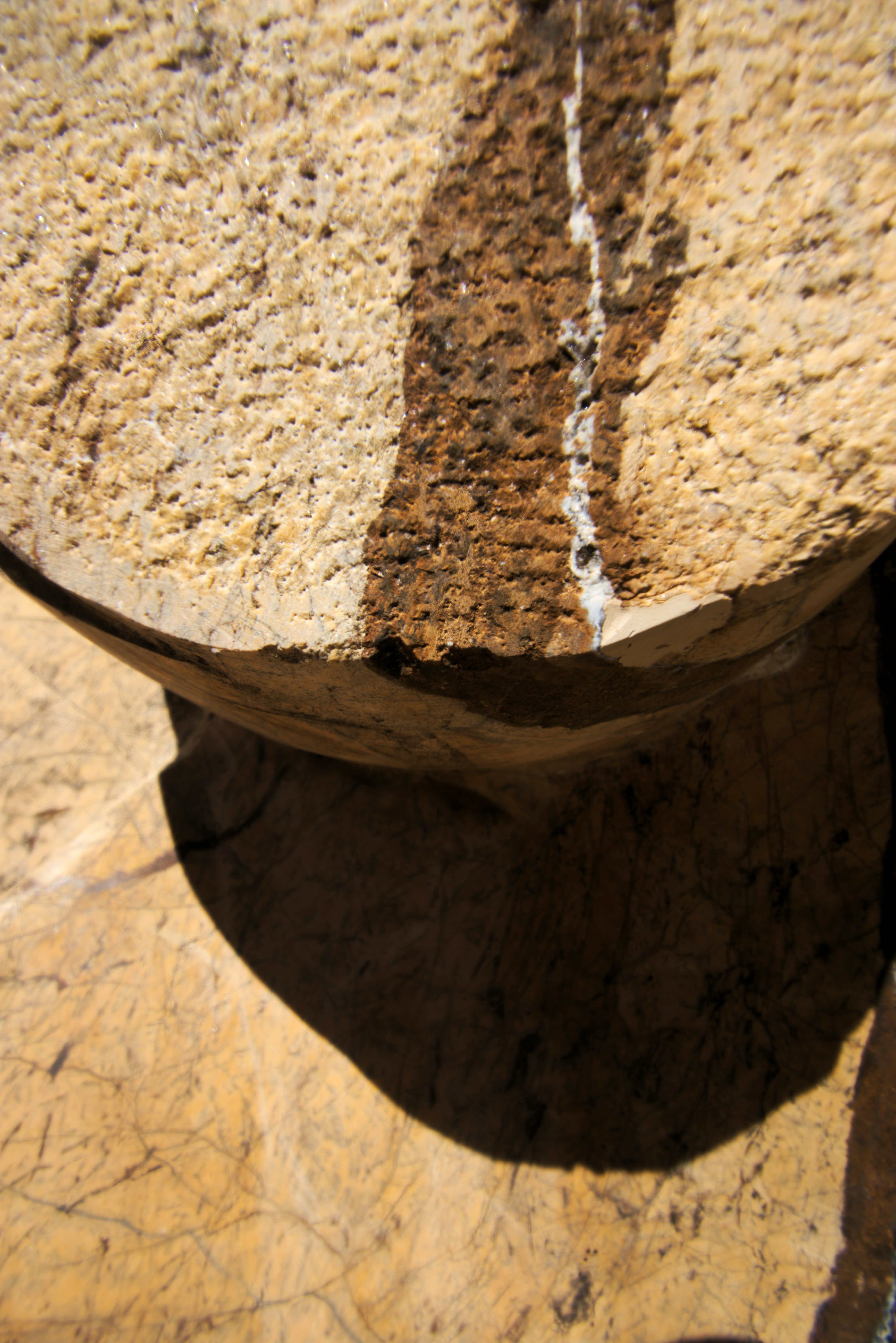Sun-Burnished Crack: A Close-Up Portrait of Ochre Rock Texture