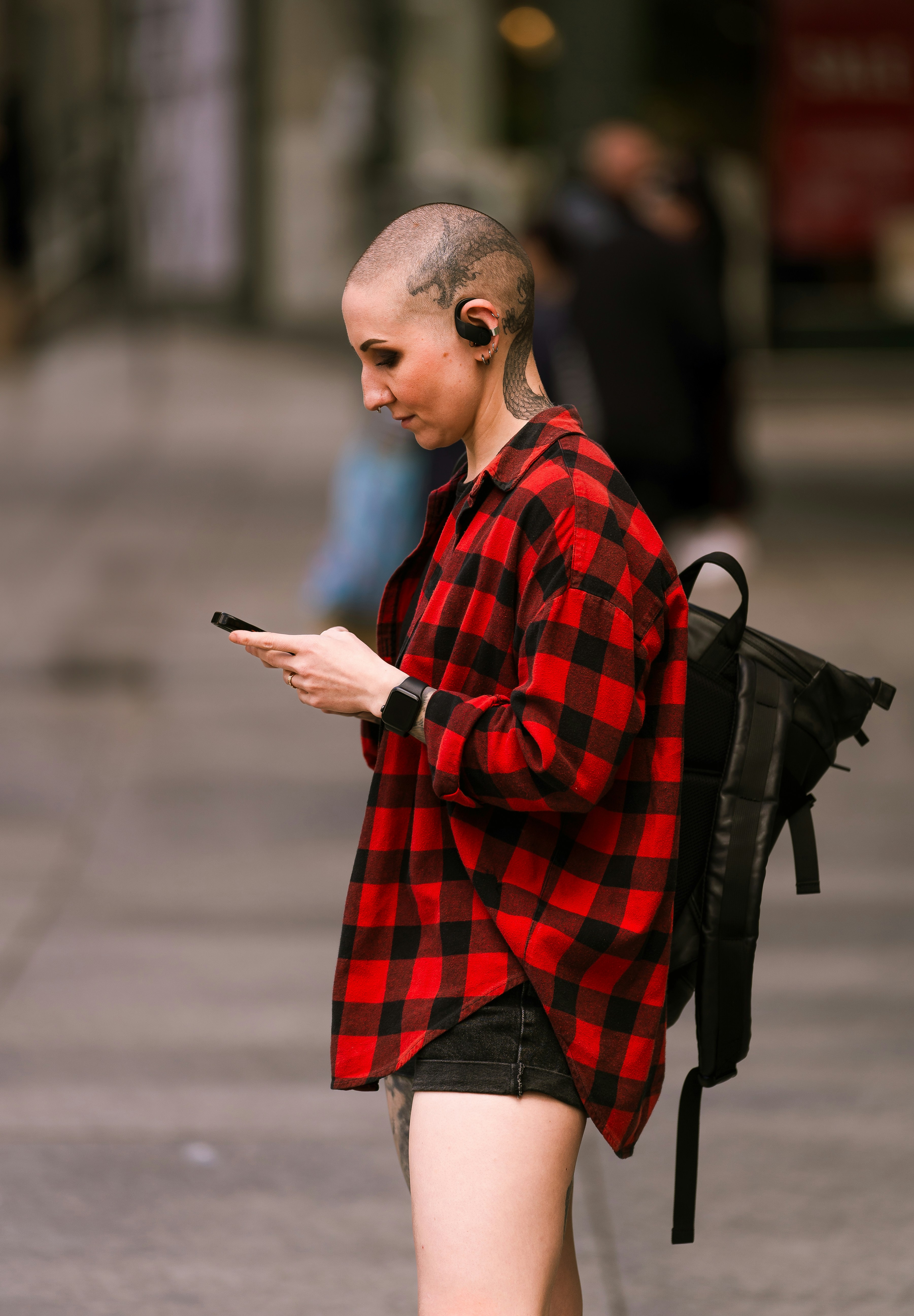 Red Plaid in the City: Focused Moment on a Smartphone