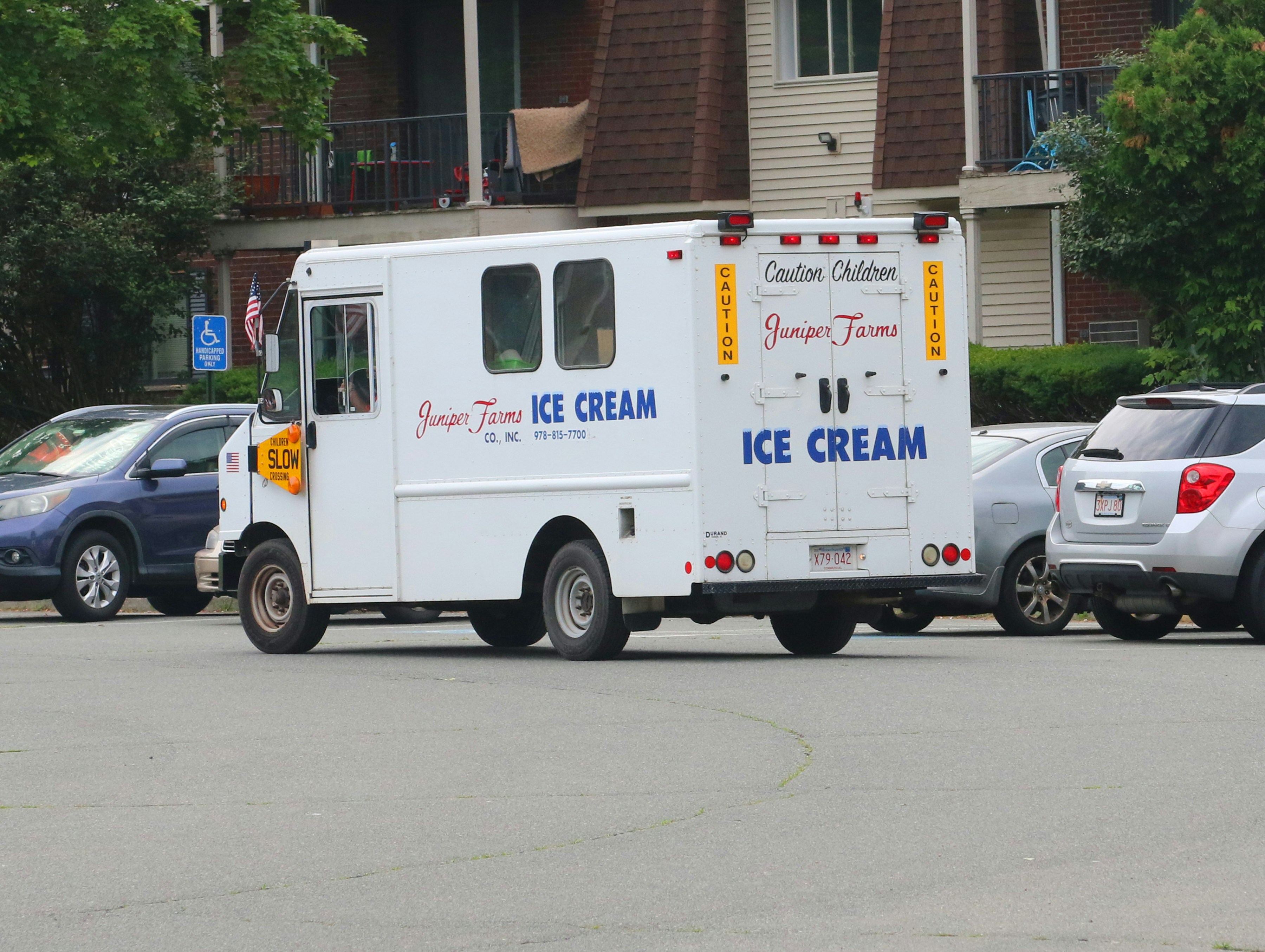 White Ice Cream Truck Anchors a Quiet Apartment Parking Lot