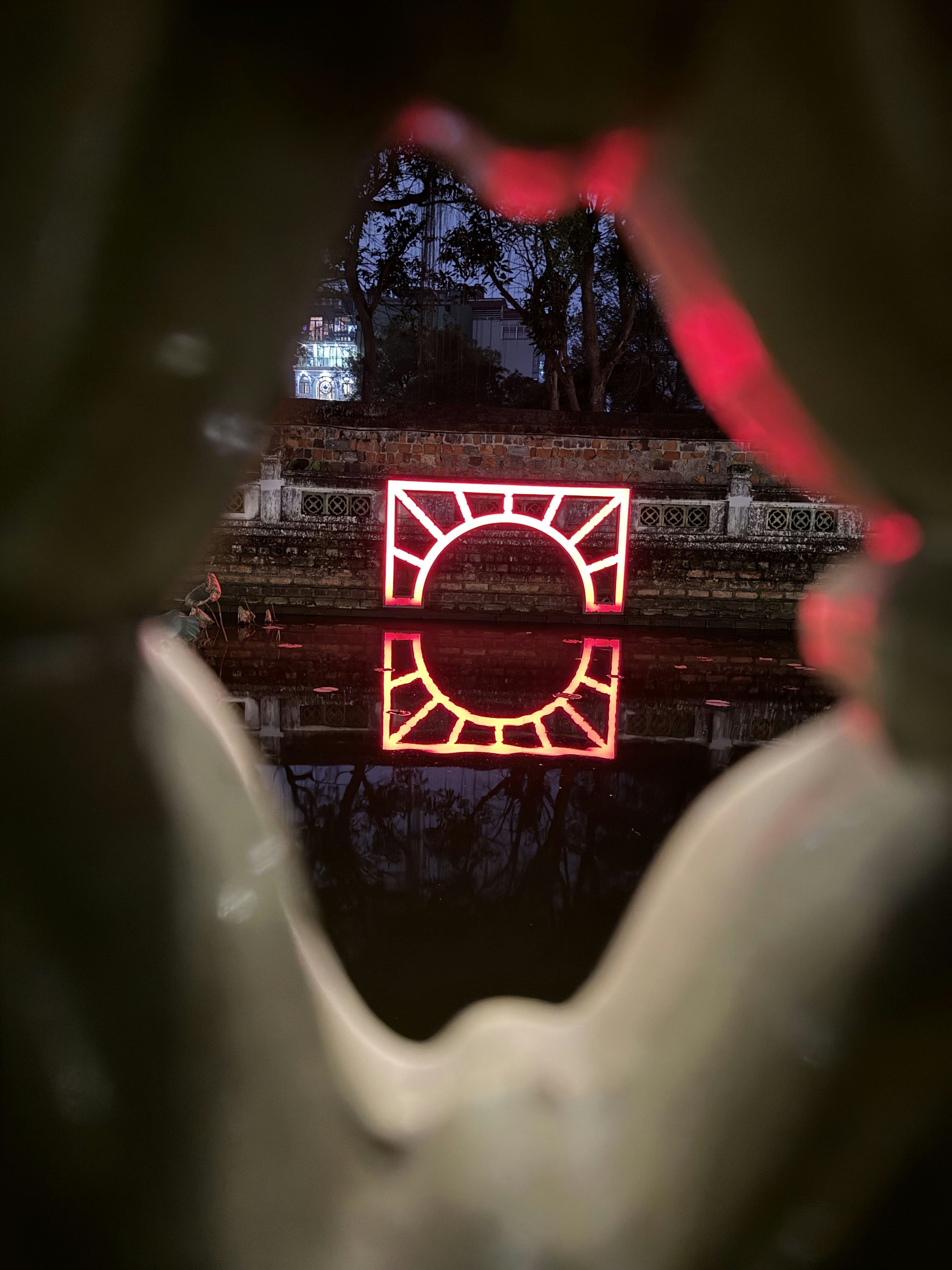 Neon Arch Reflected Through a Carved Frame at Night