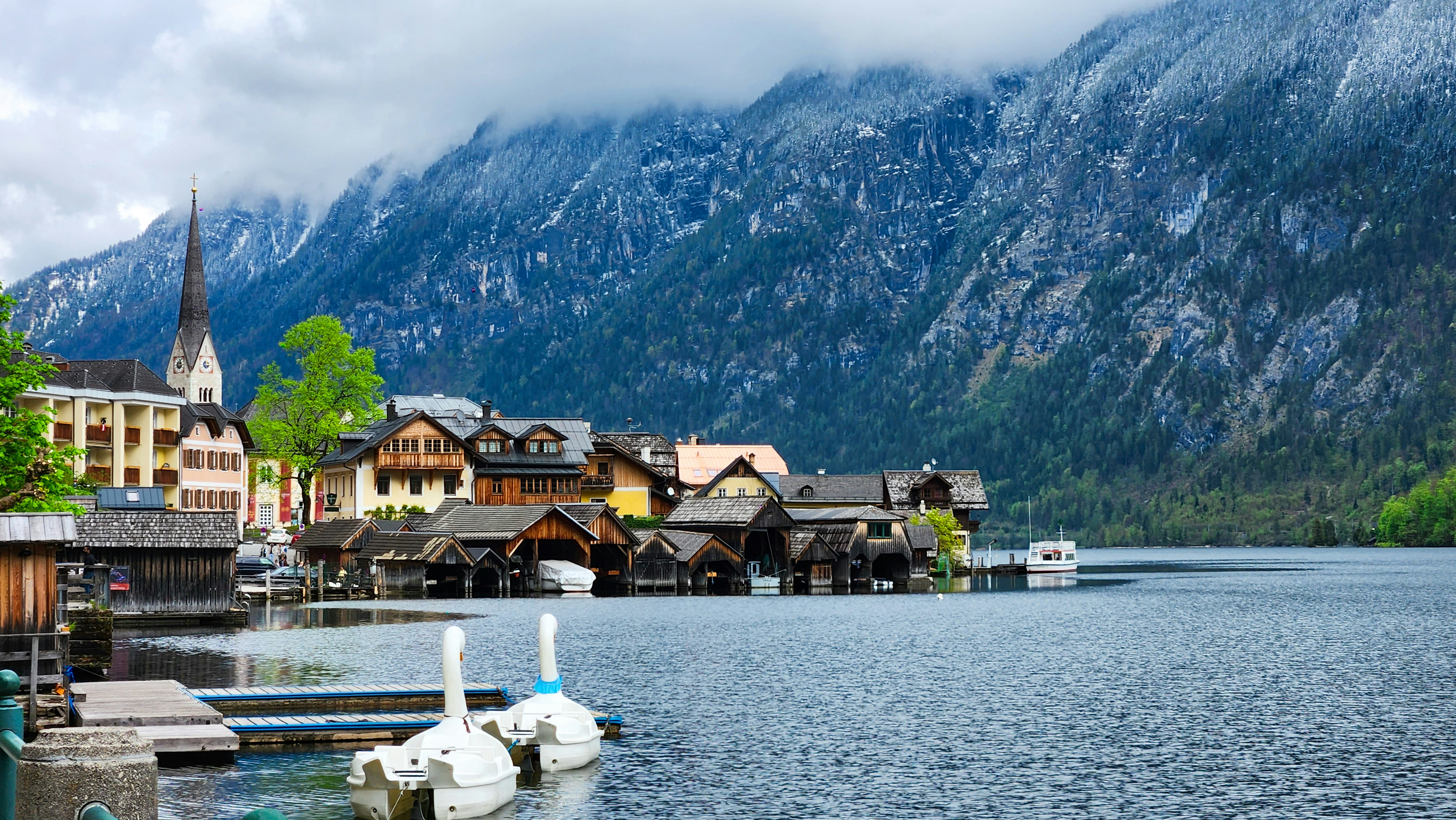 Alpine Spire Over Calm Waters: A Lakeside Village at the Foot of Jagged Peaks