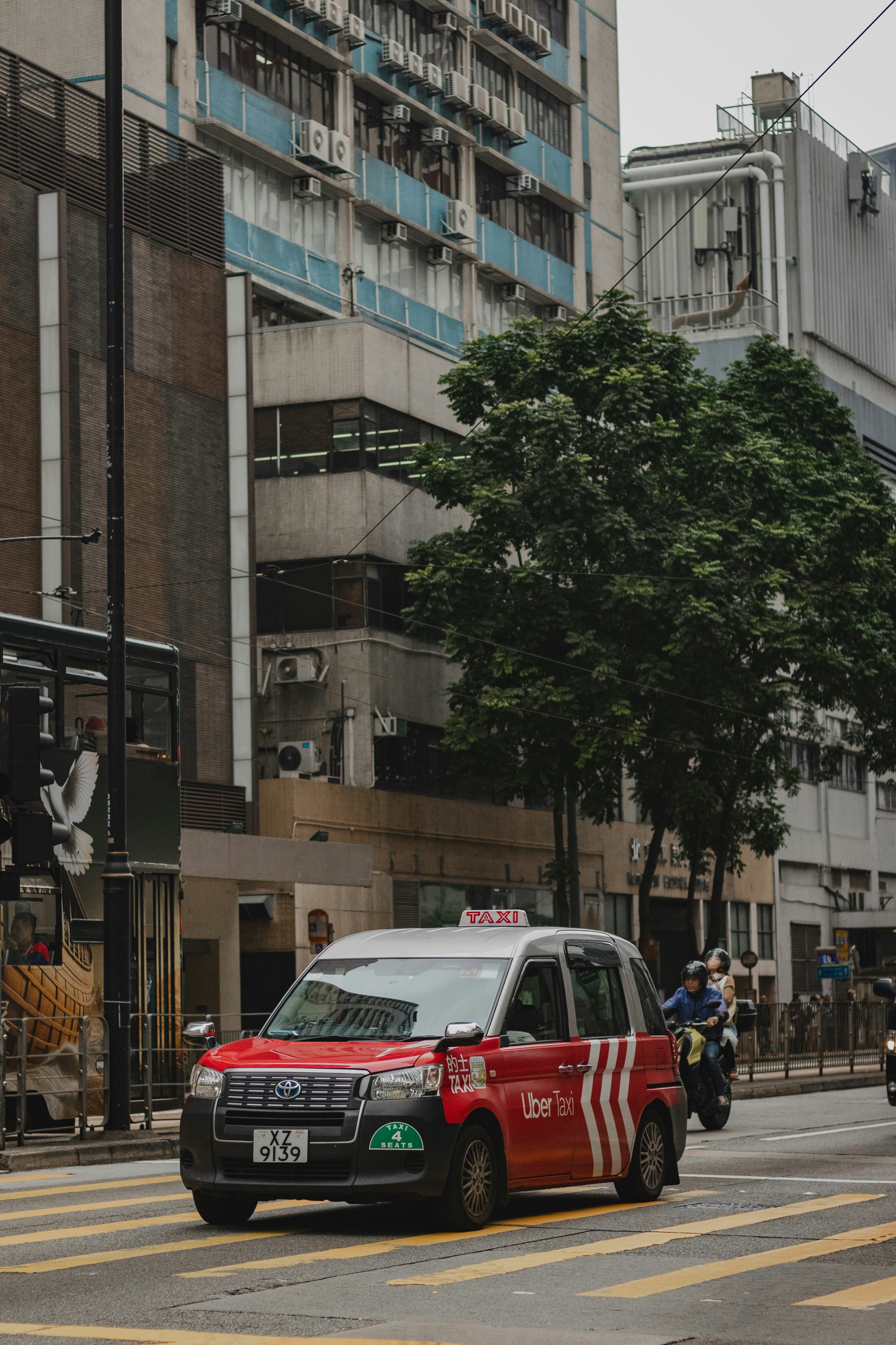 Red Uber Taxi Cutting Through a City Street Canyon