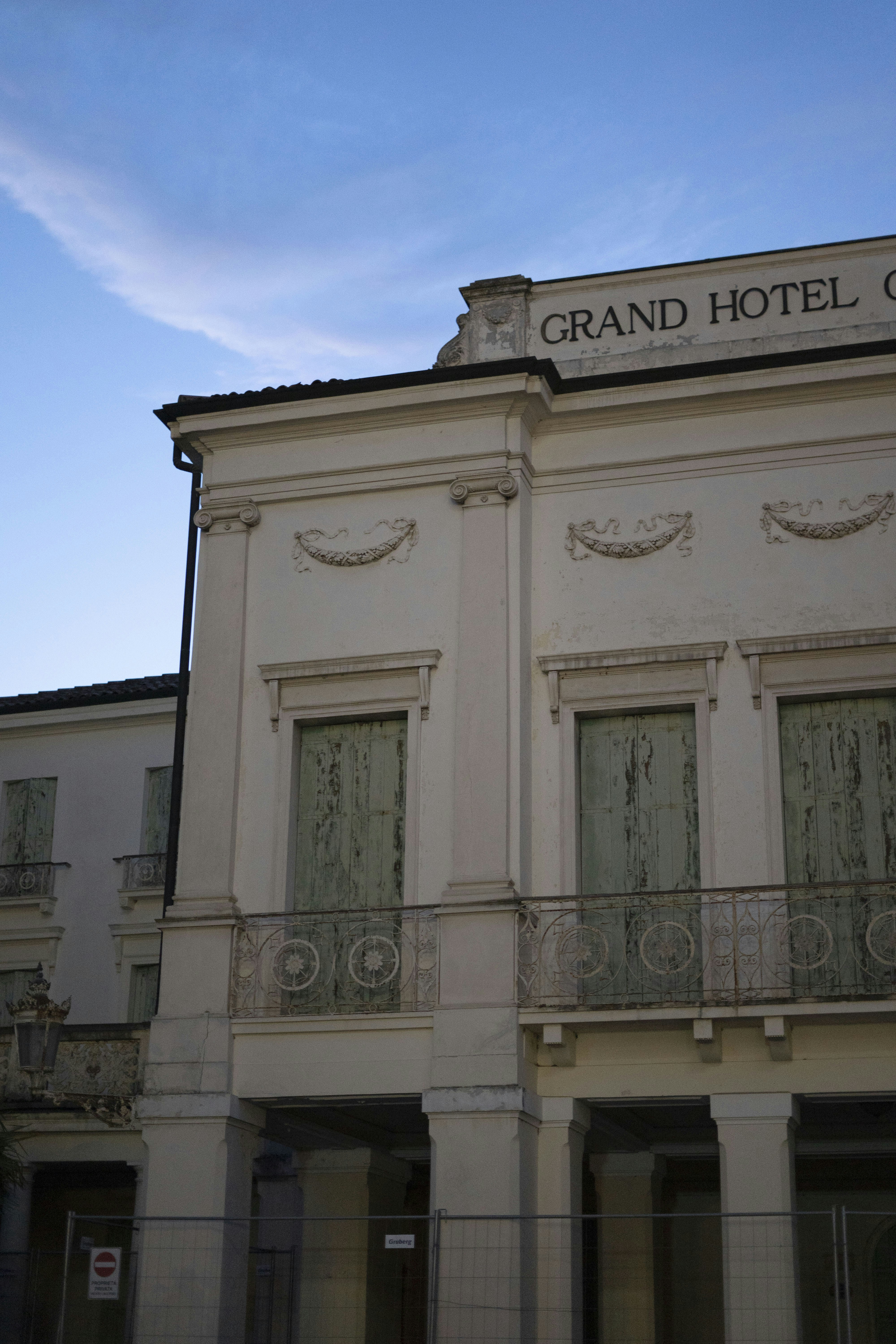 Historic hotel facade with ornate details against a clear blue sky.