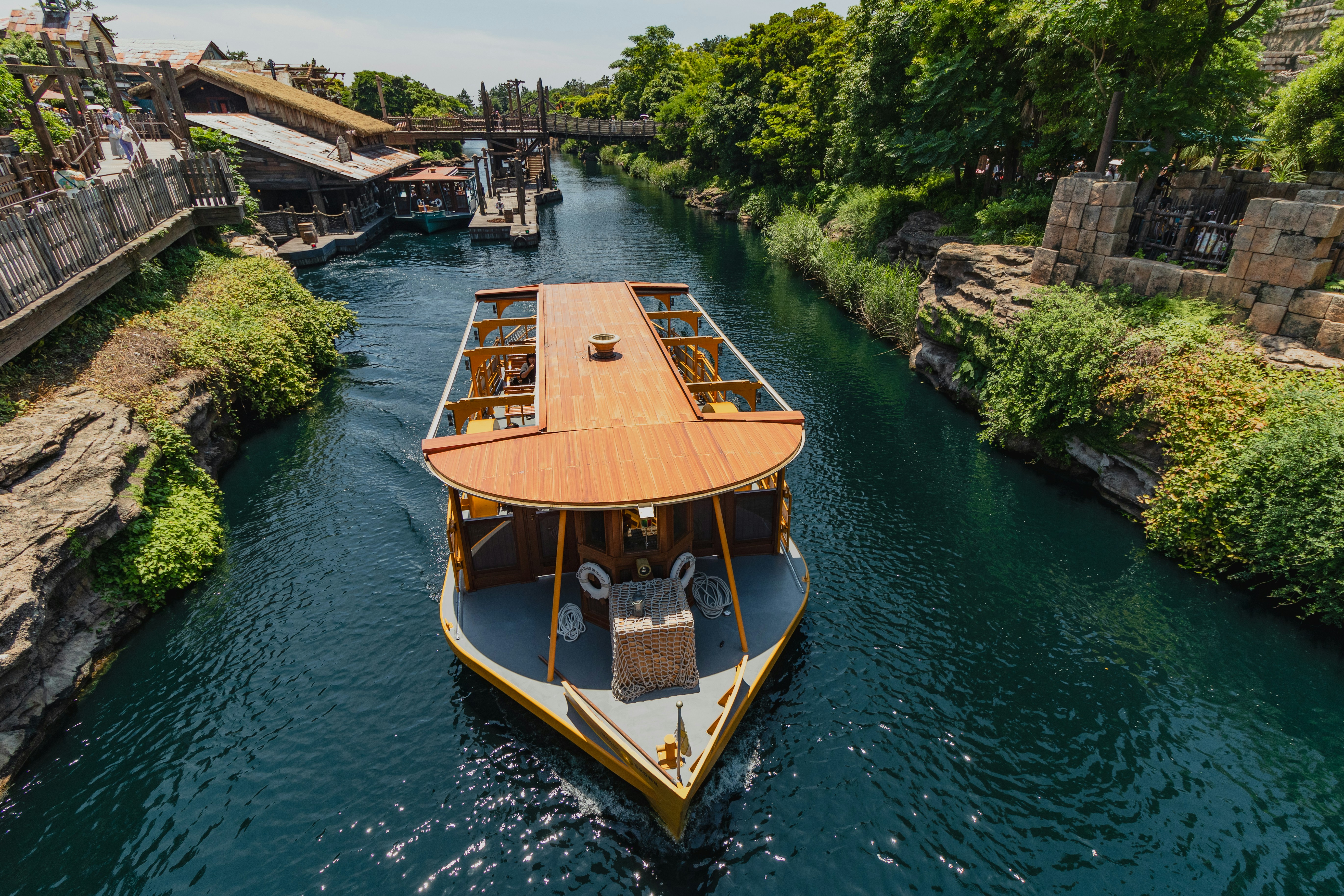 A boat traveling down a river next to a bridge photo – Free Boat Image ...