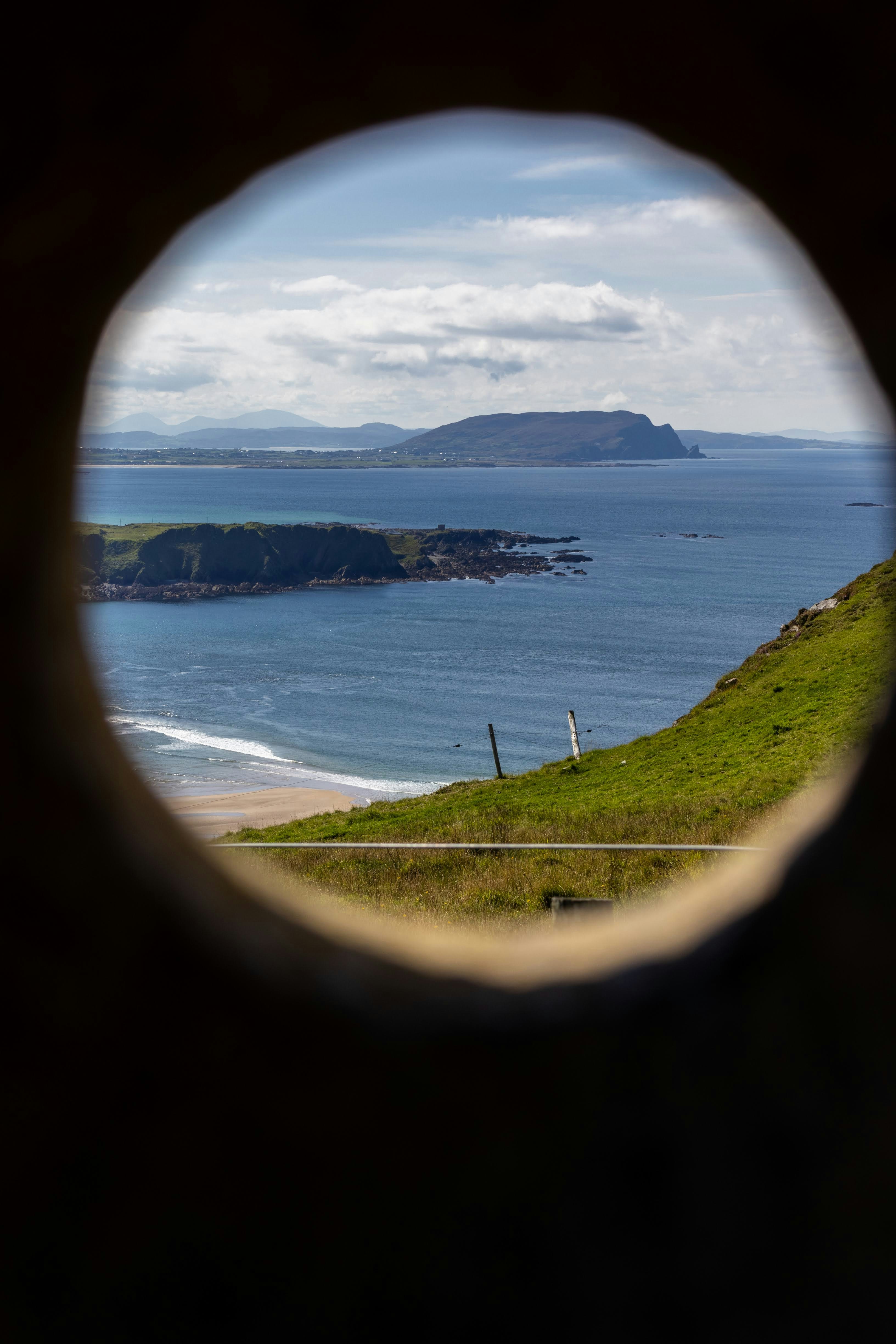 Circular Window on the Coast: Island Horizon Framed by a Tunnel of Light
