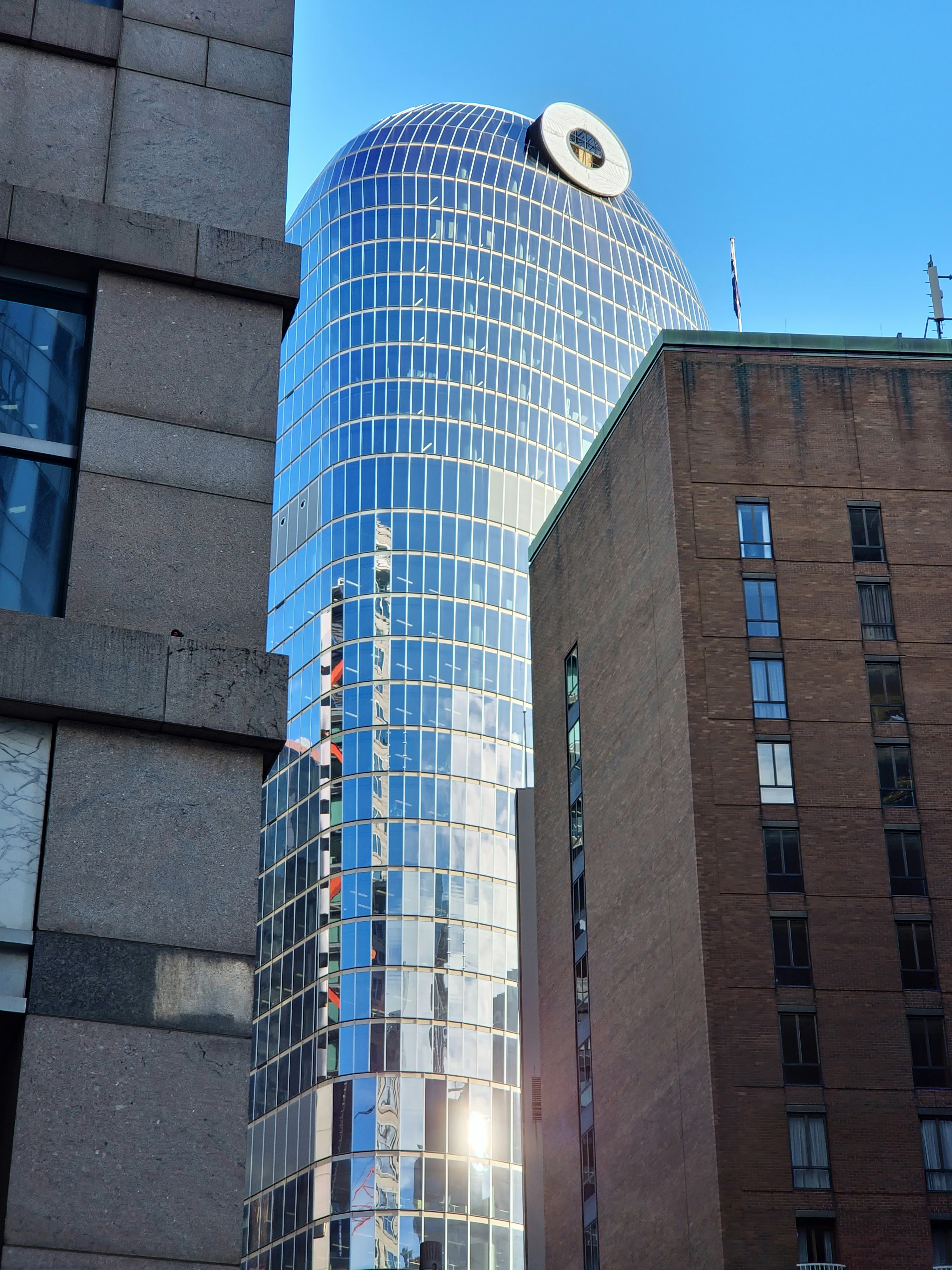 Sunlit Glass Spire Framed by Brick Facades