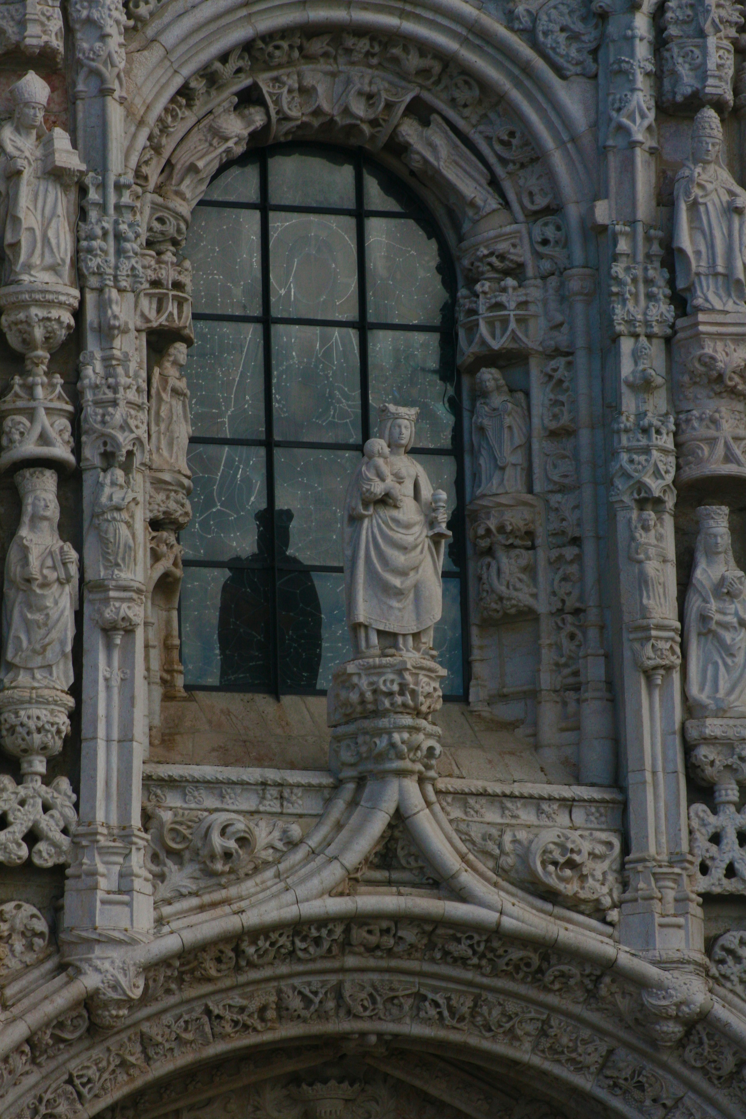 Stone Sentinel Beneath a Gothic Window: A Carved Facade Portrait