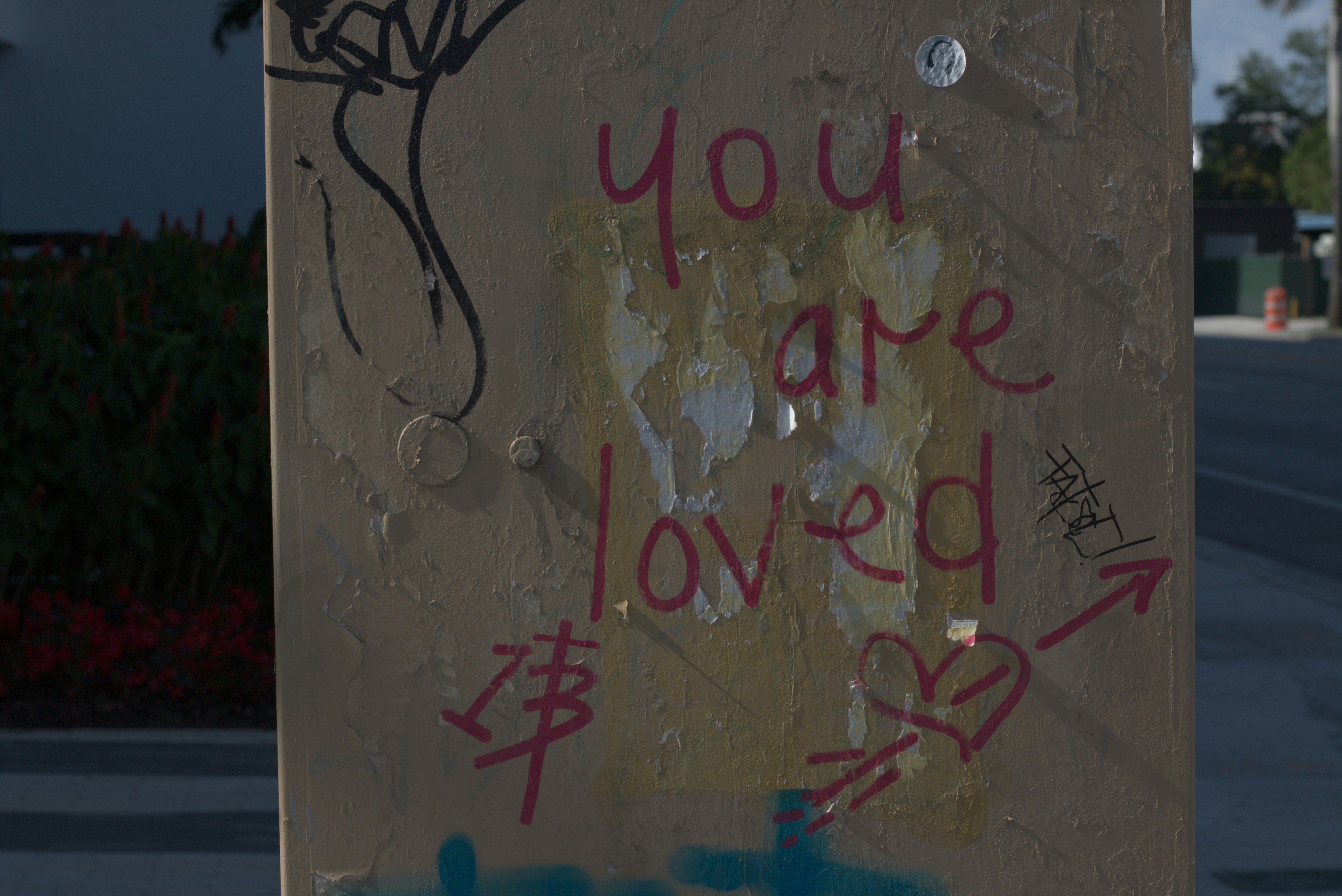You Are Loved: Pink Graffiti on a Weathered Urban Pillar