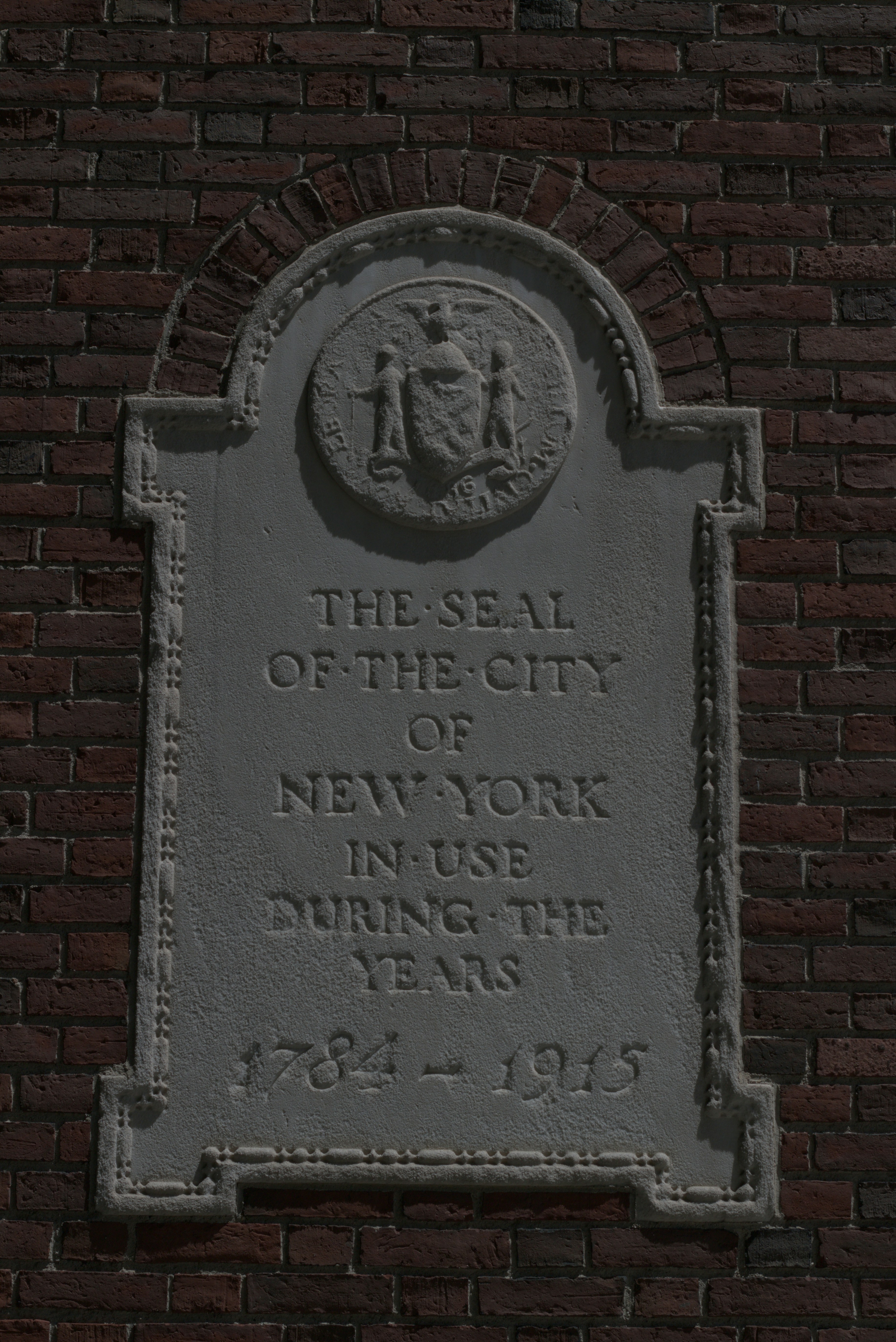 Inscribed Stone Plaque on Brick Wall