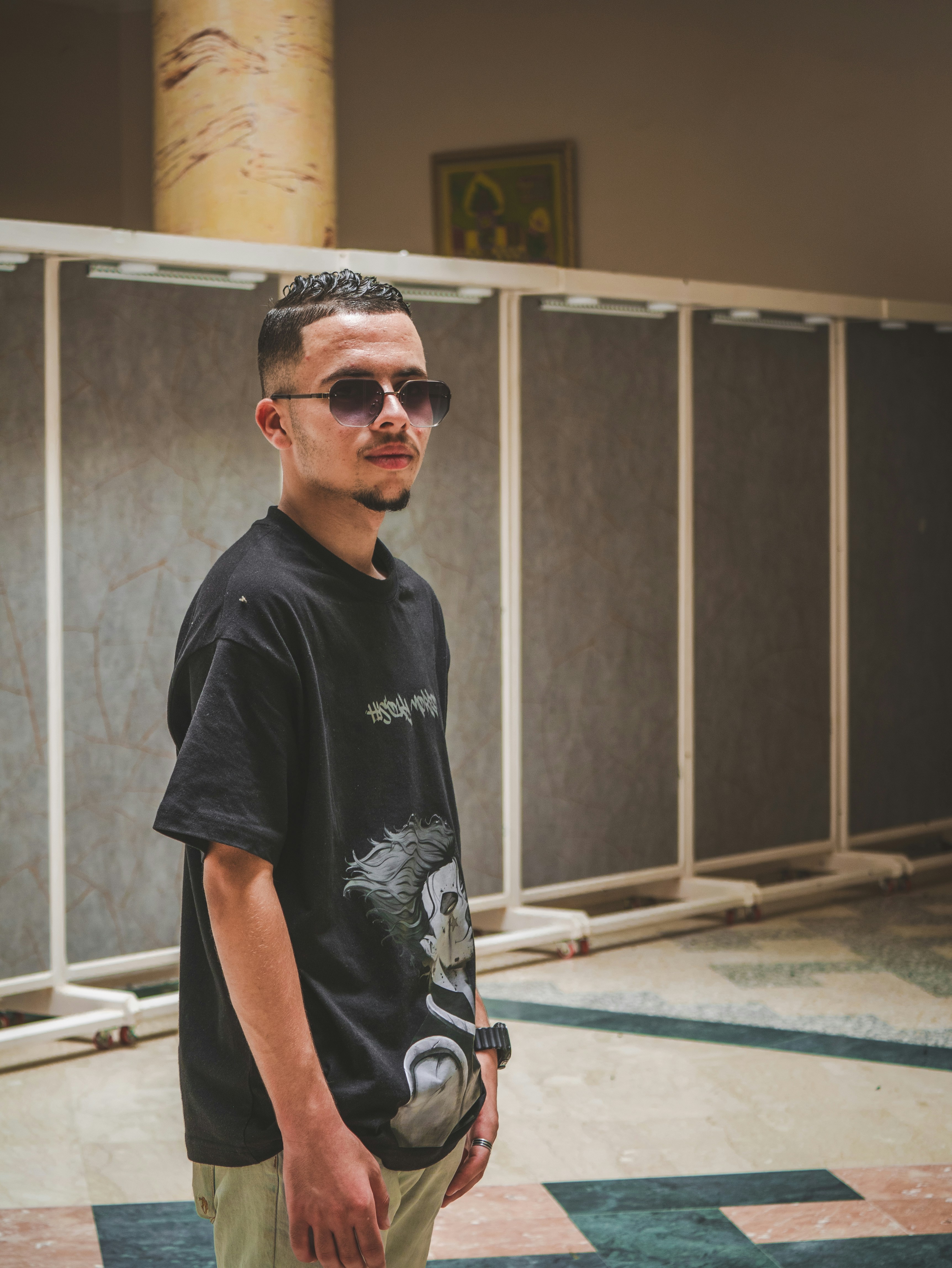 A man standing in front of a row of stalls photo – Free Portrait Image ...