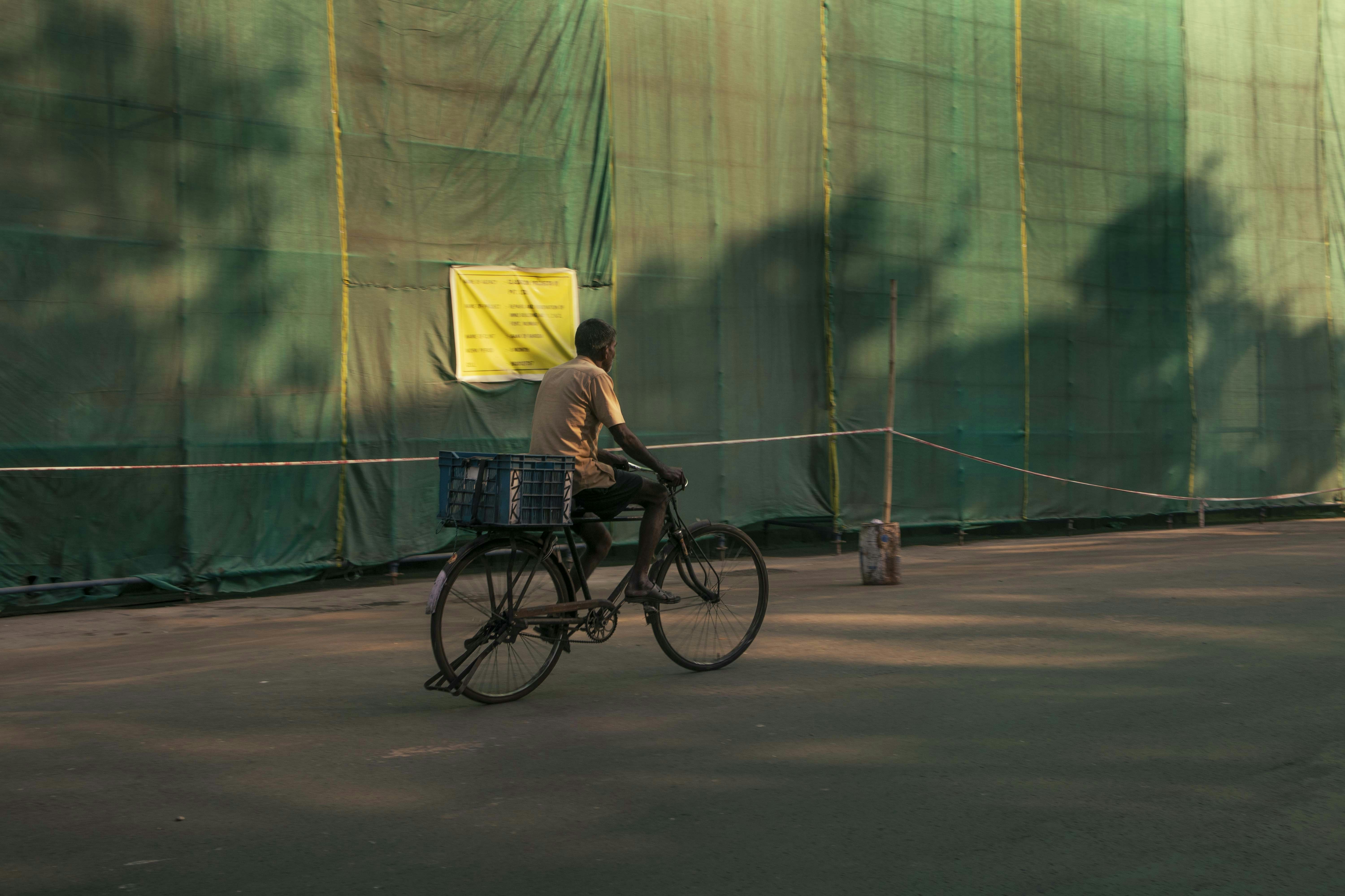 Lone Courier on a Quiet Street: Cargo Bike against a Green Facade