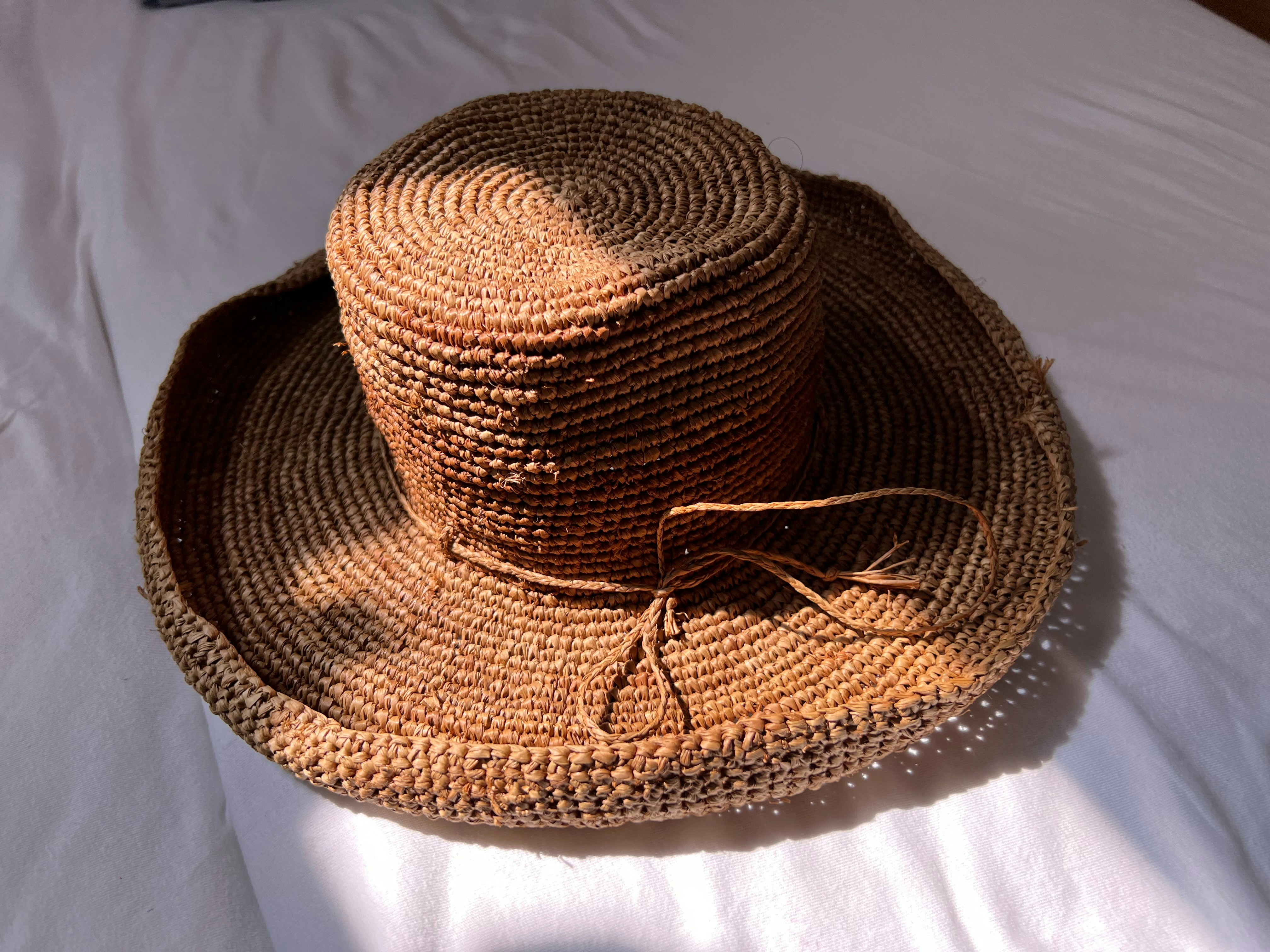 A straw hat sitting on top of a bed photo – Free Hat Image on Unsplash