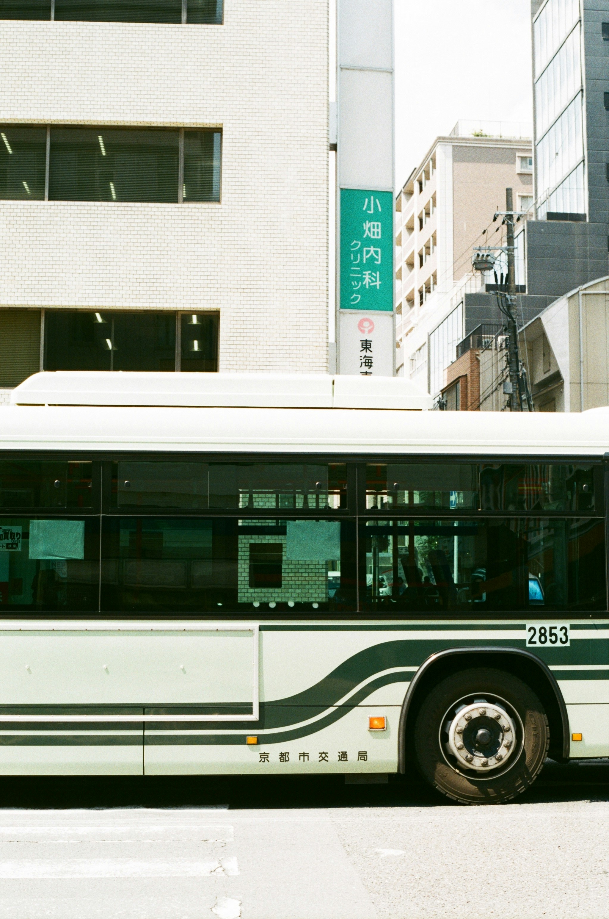 A white bus driving down a street next to tall buildings photo – Free ...
