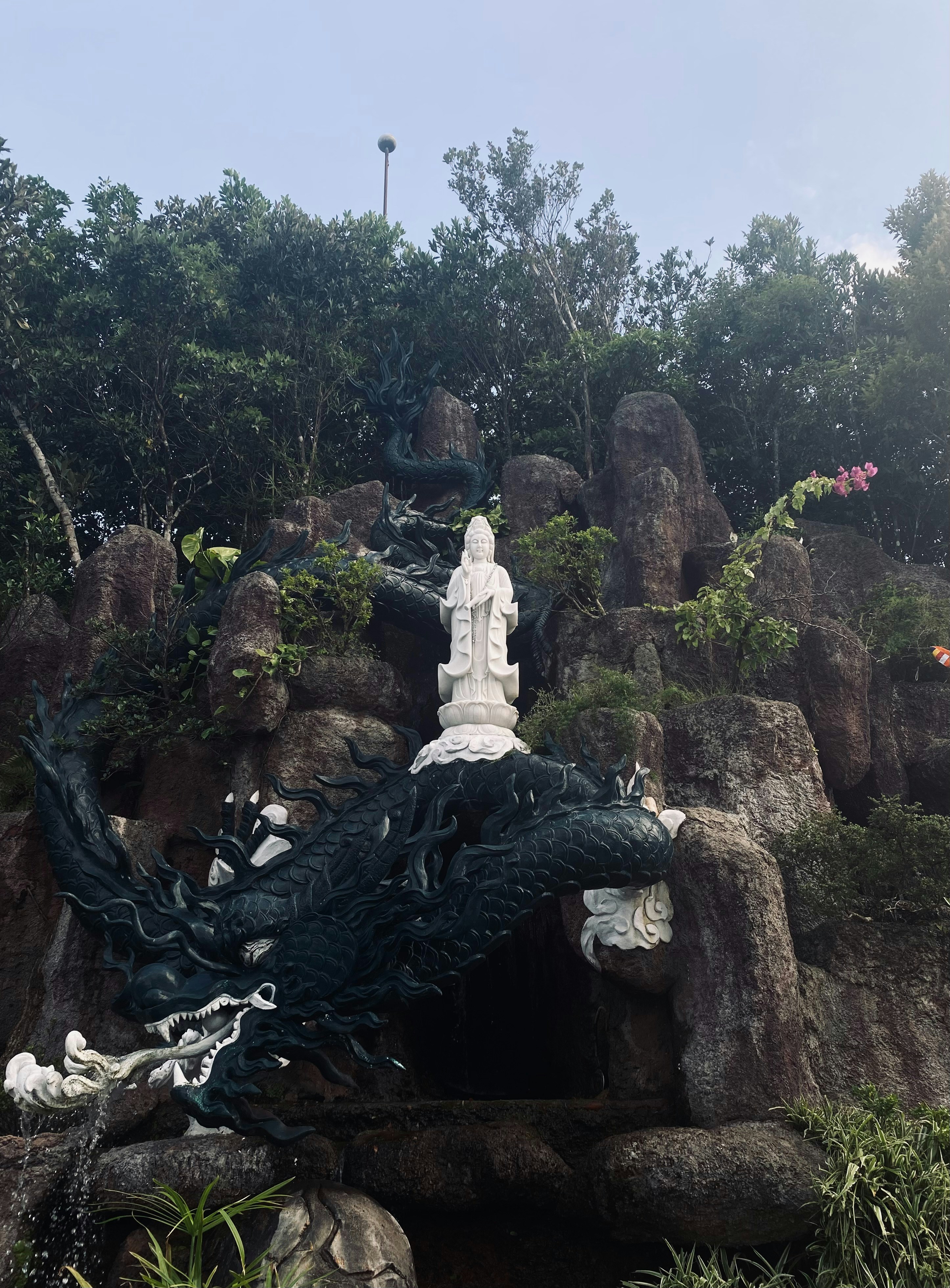 Bodhisattva Above the Dragon: Quiet Majesty in a Rocky Garden