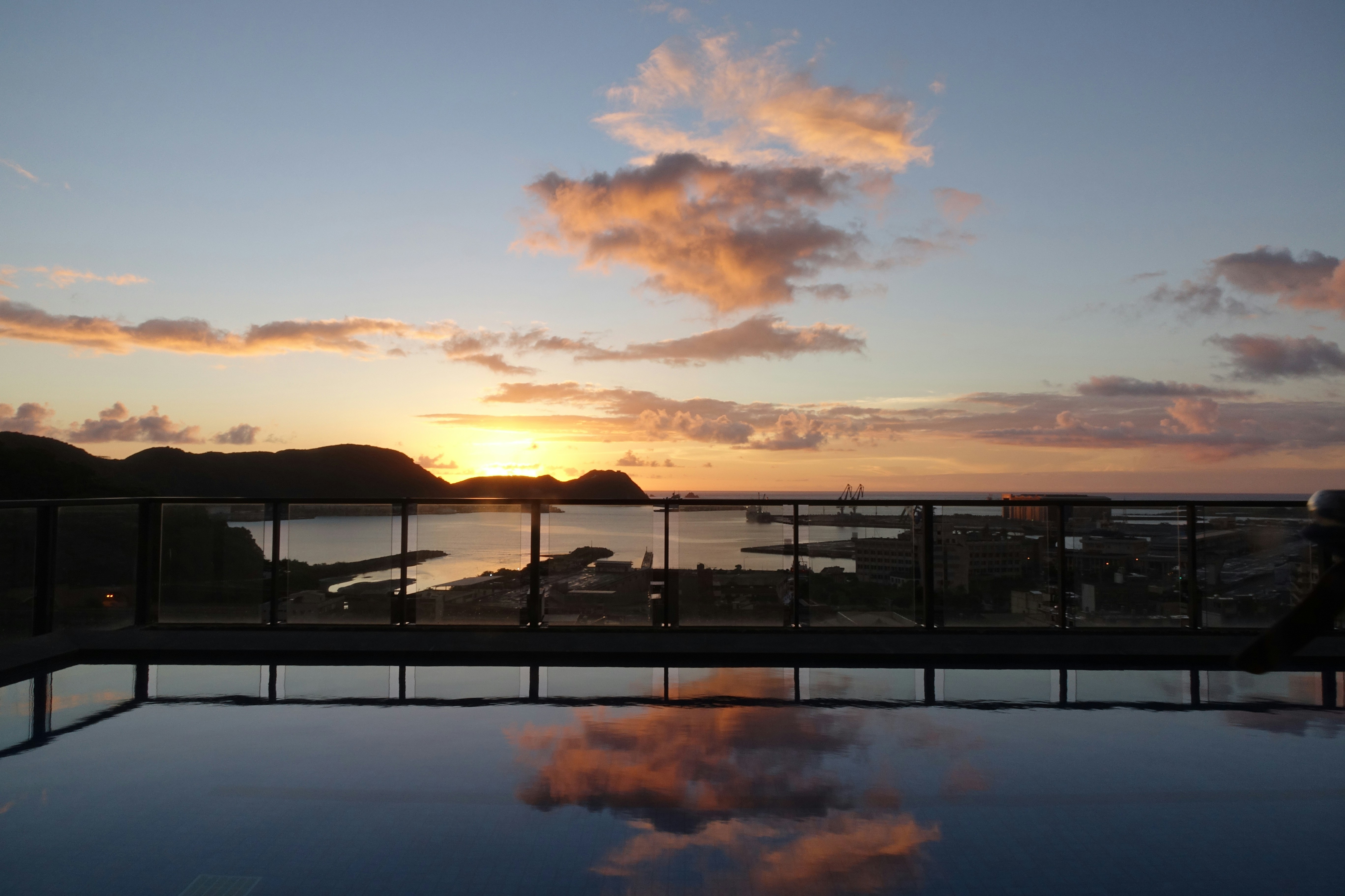 A pool with a sunset in the background