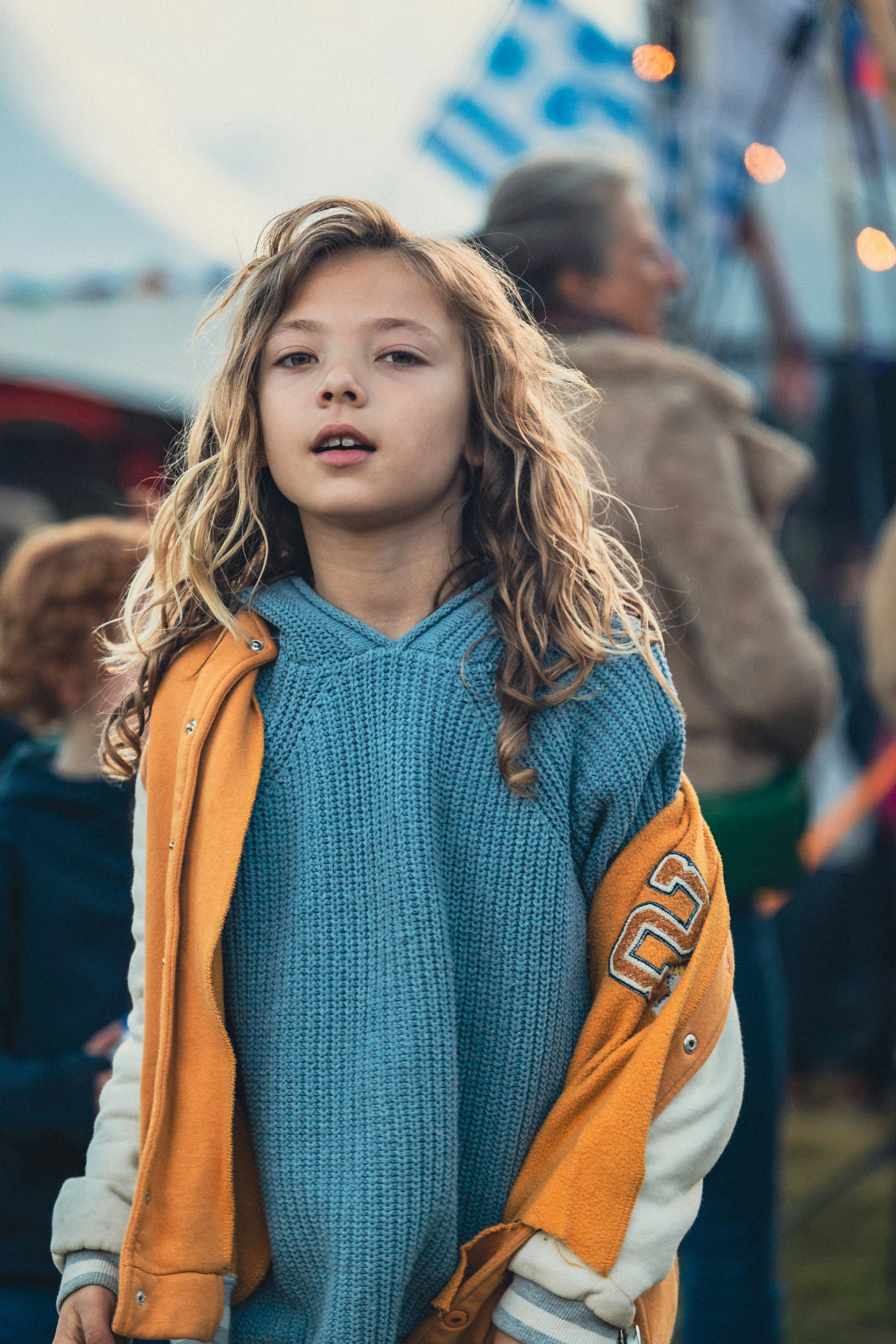 A little girl standing in front of a crowd of people photo – Free ...