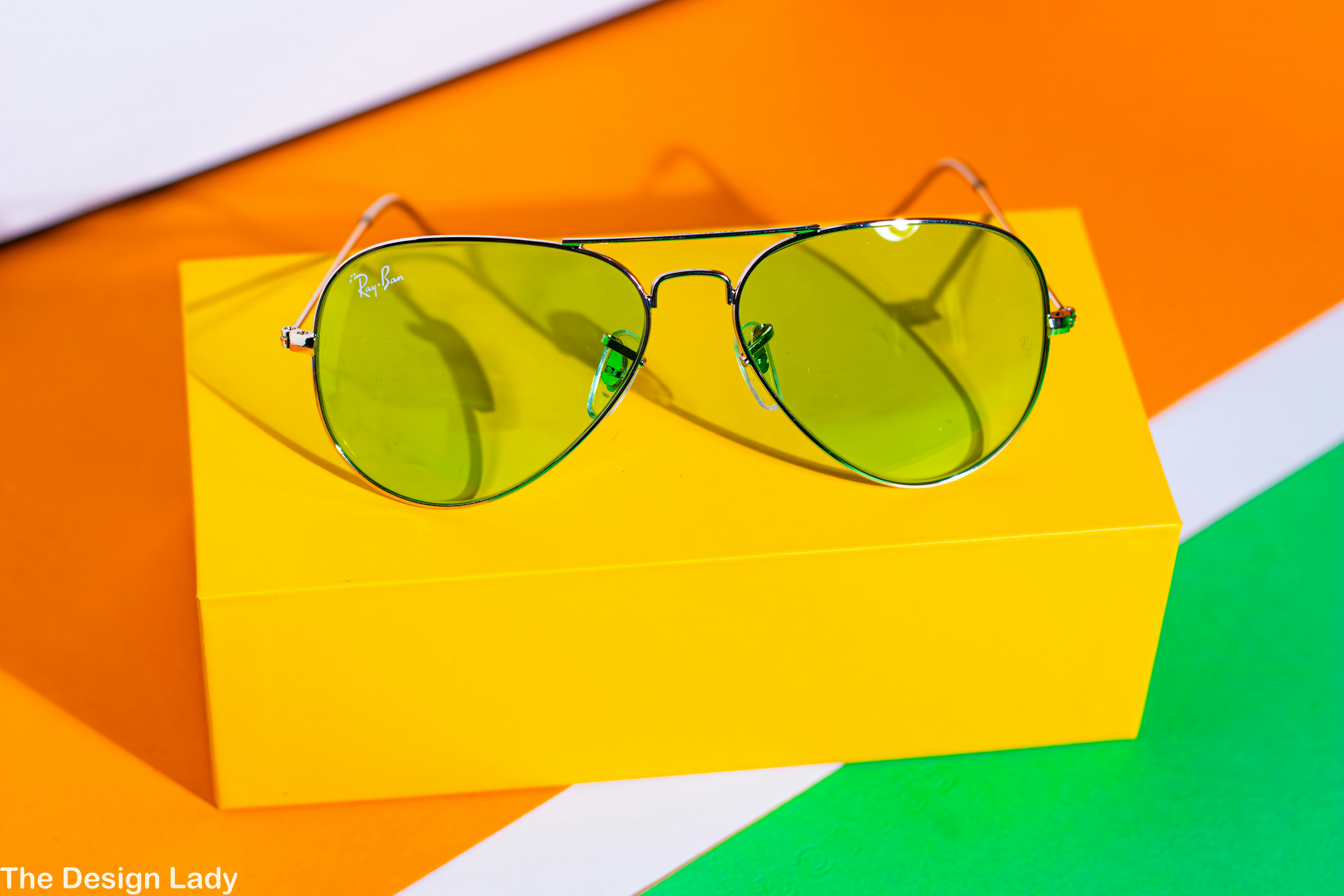 Ray-Ban Aviators on a Neon Yellow Pedestal Amid Bold Color Blocks