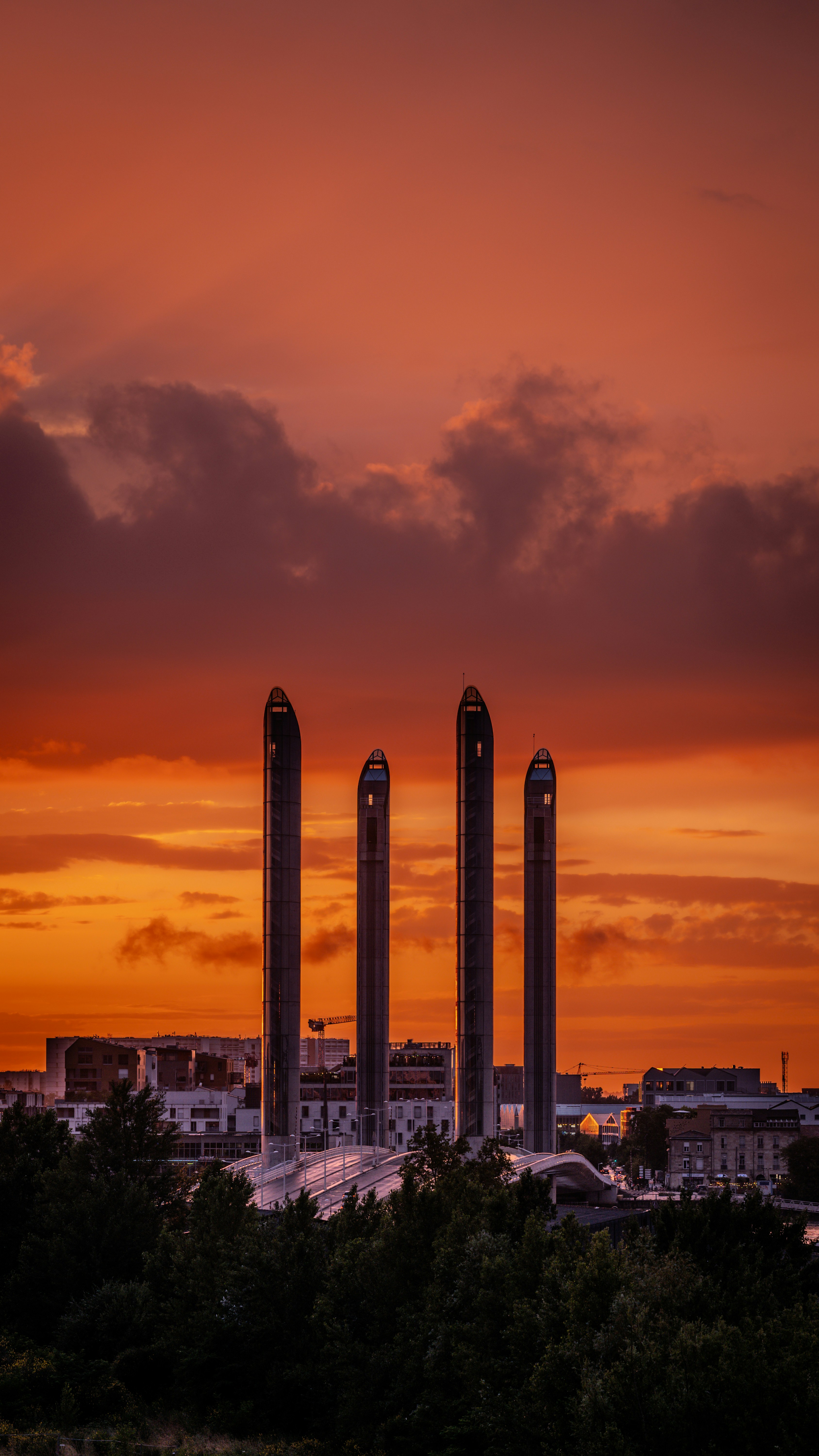 Quadruple Chimneys at Sunset: Iron Sentinels Against a Tangerine Sky