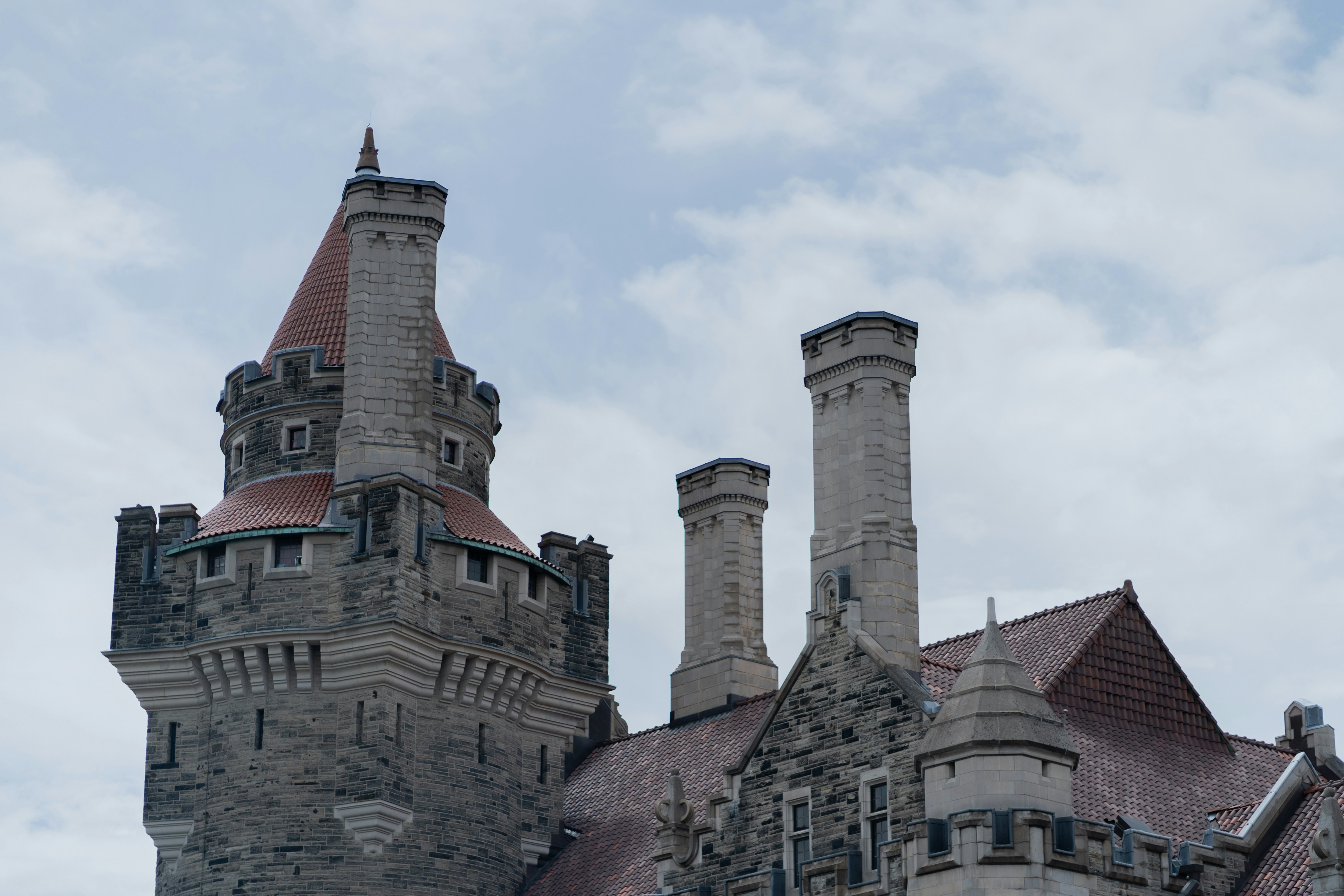 Red-Tiled Turrets Crown a Weathered Castle Under a Pale Sky