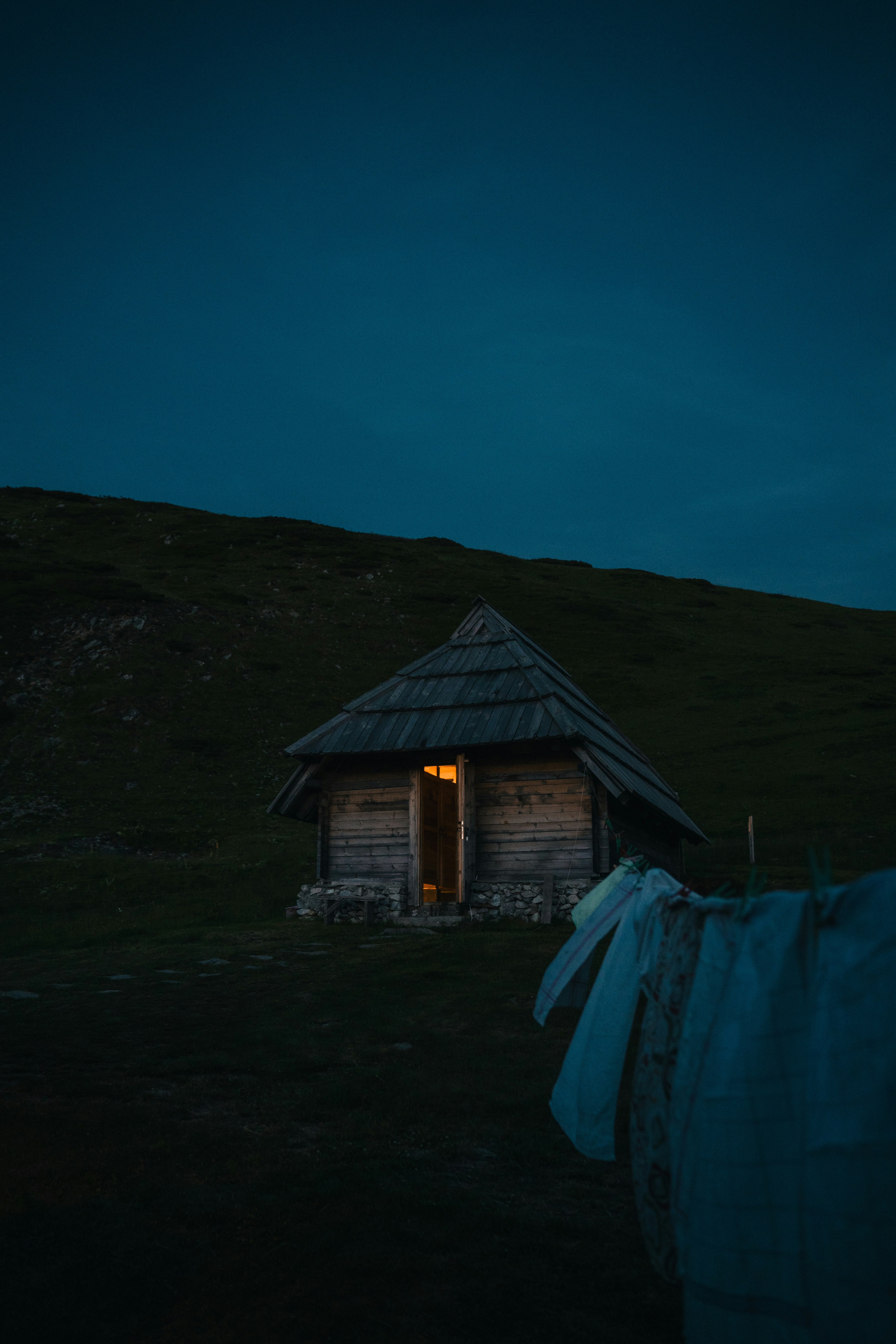 A person standing in front of a hut at night photo – Free Montenegro ...