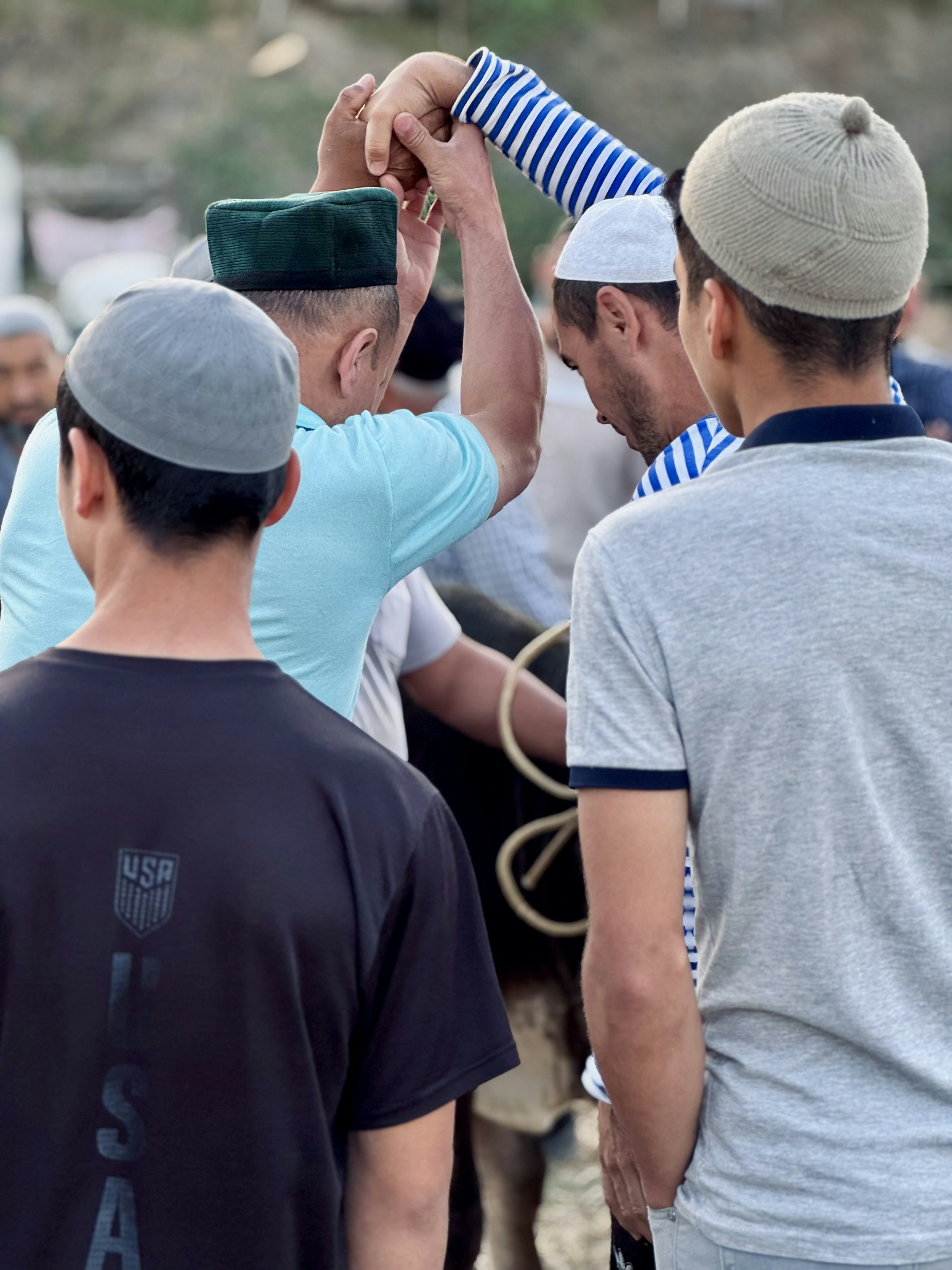 A group of men standing around each other photo – Free Kosonsoy Image ...