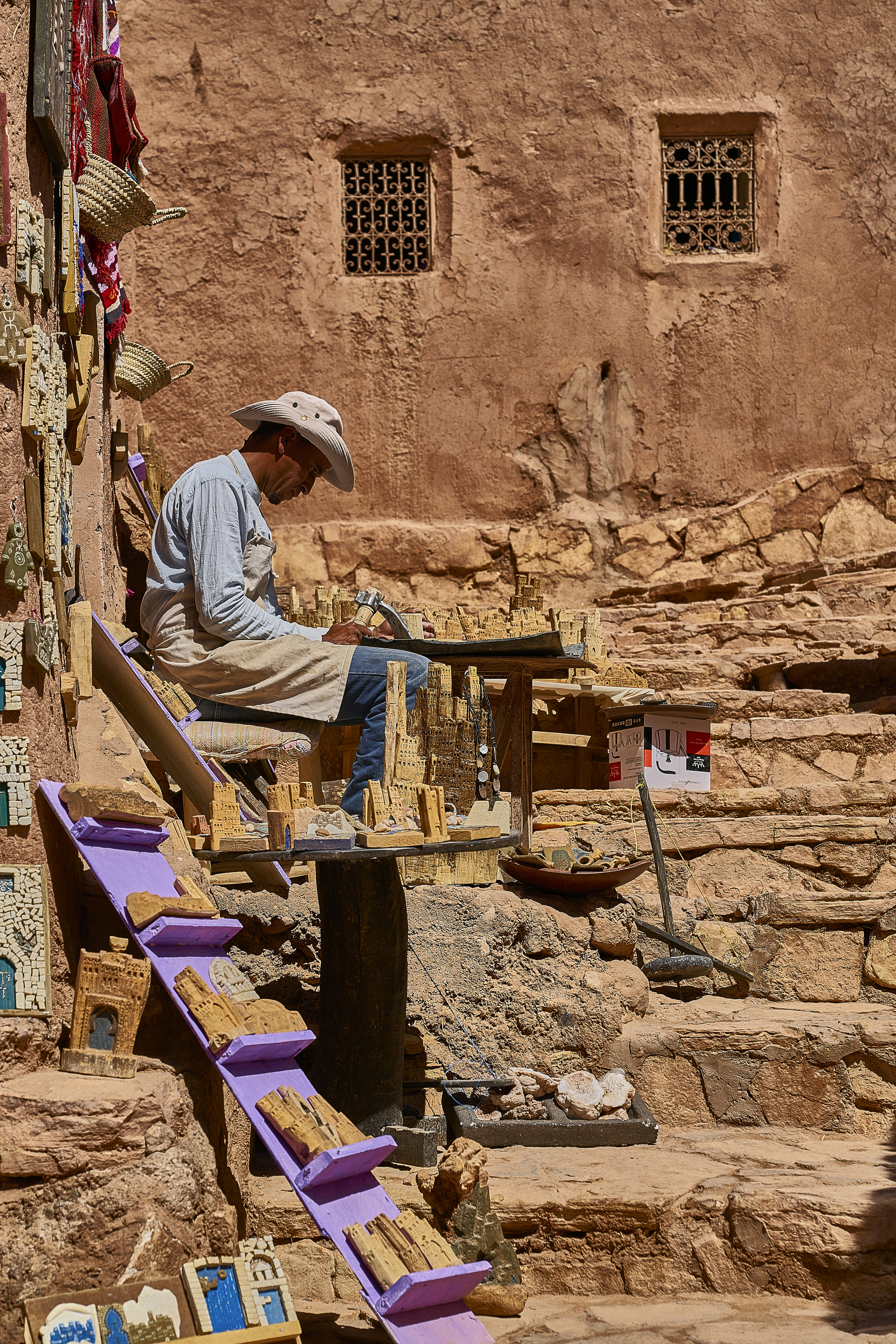 Terraced Silence: A Craftsman Carving in a Sun-Baked Adobe Courtyard