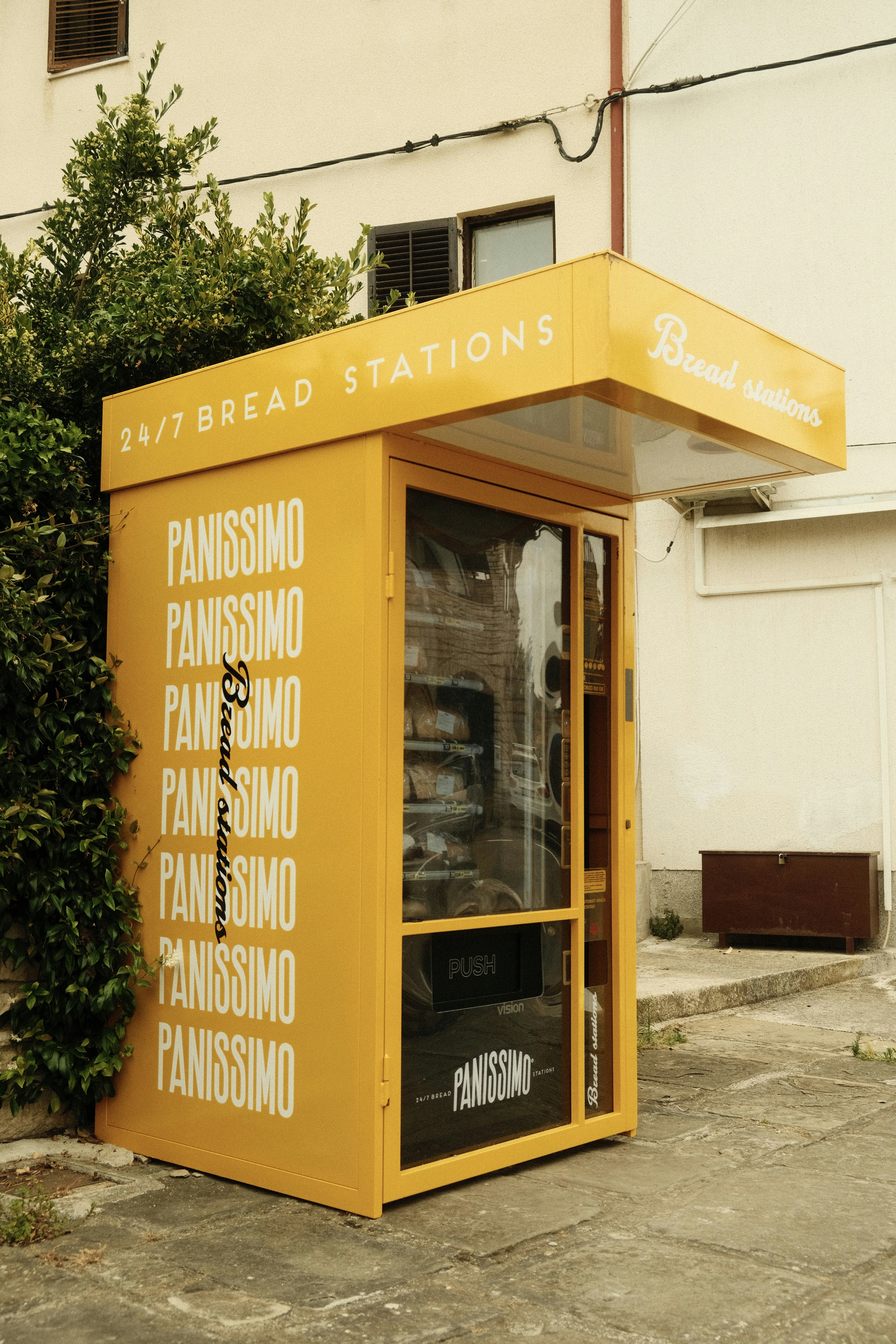 Sunlit Yellow Bread Station at the Edge of a Quiet Street
