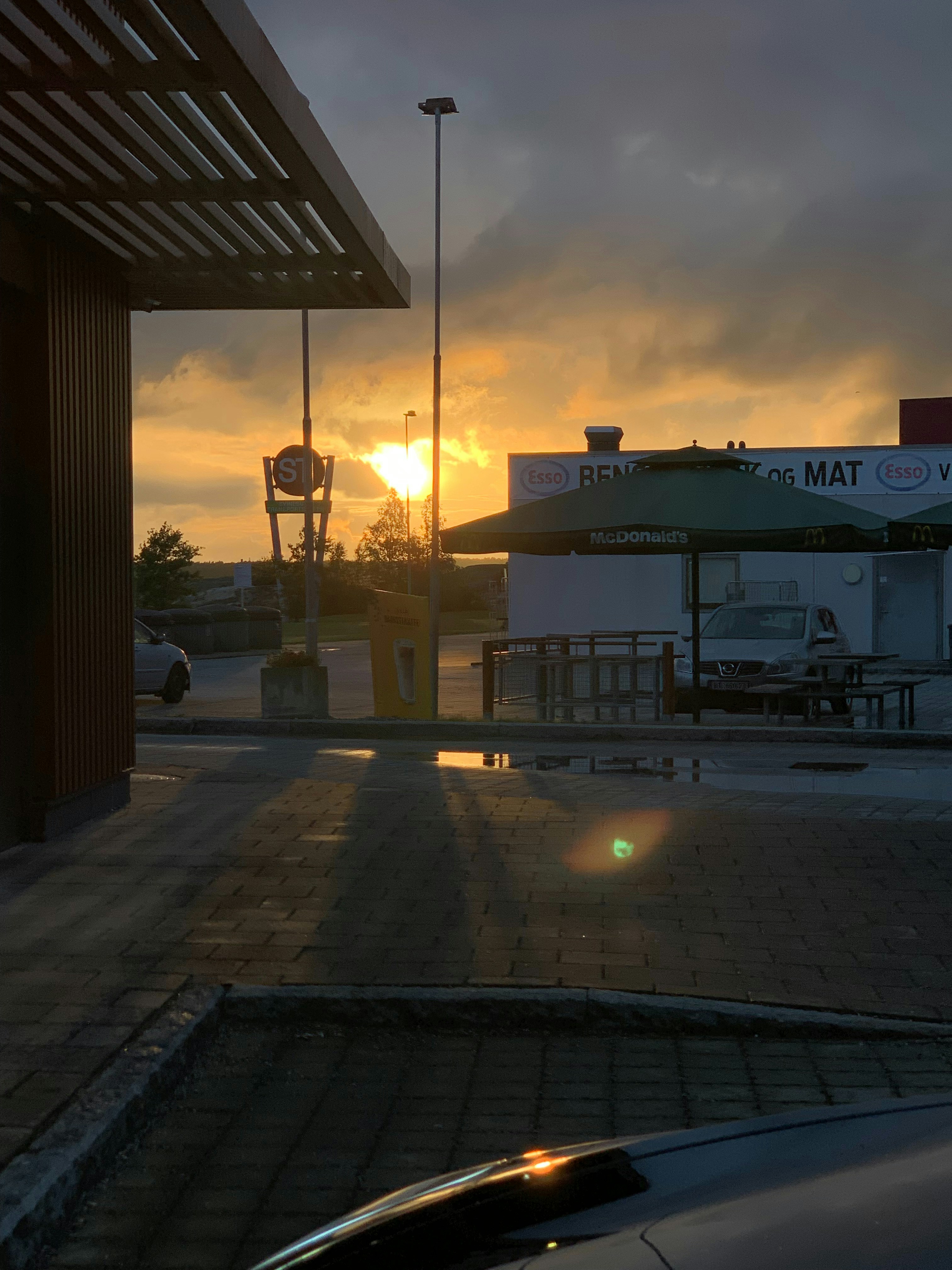 Sunset casting warm hues over a McDonald's parking lot with silhouetted architecture.