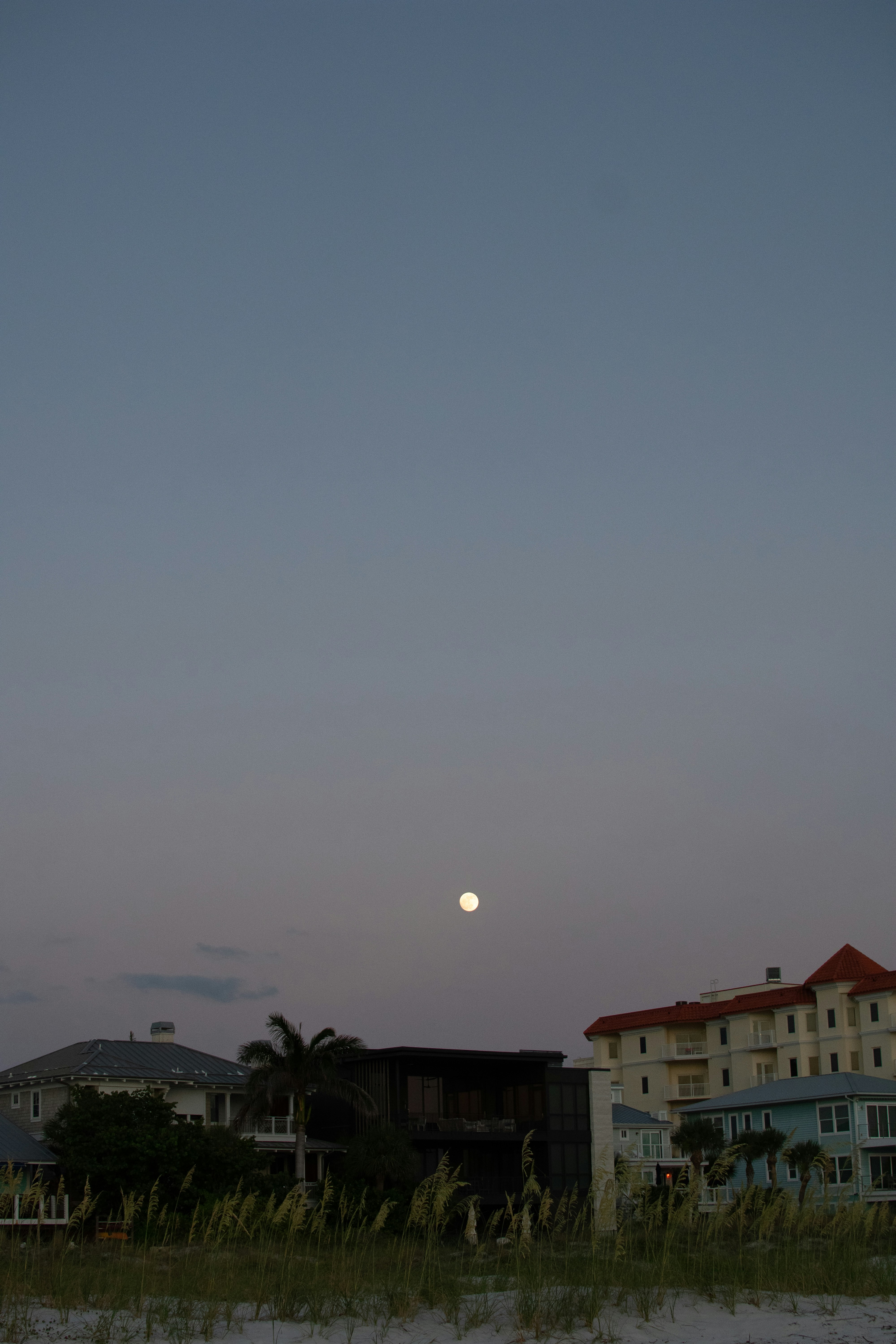 A full moon is seen in the sky over a beach photo – Free Clearwater ...