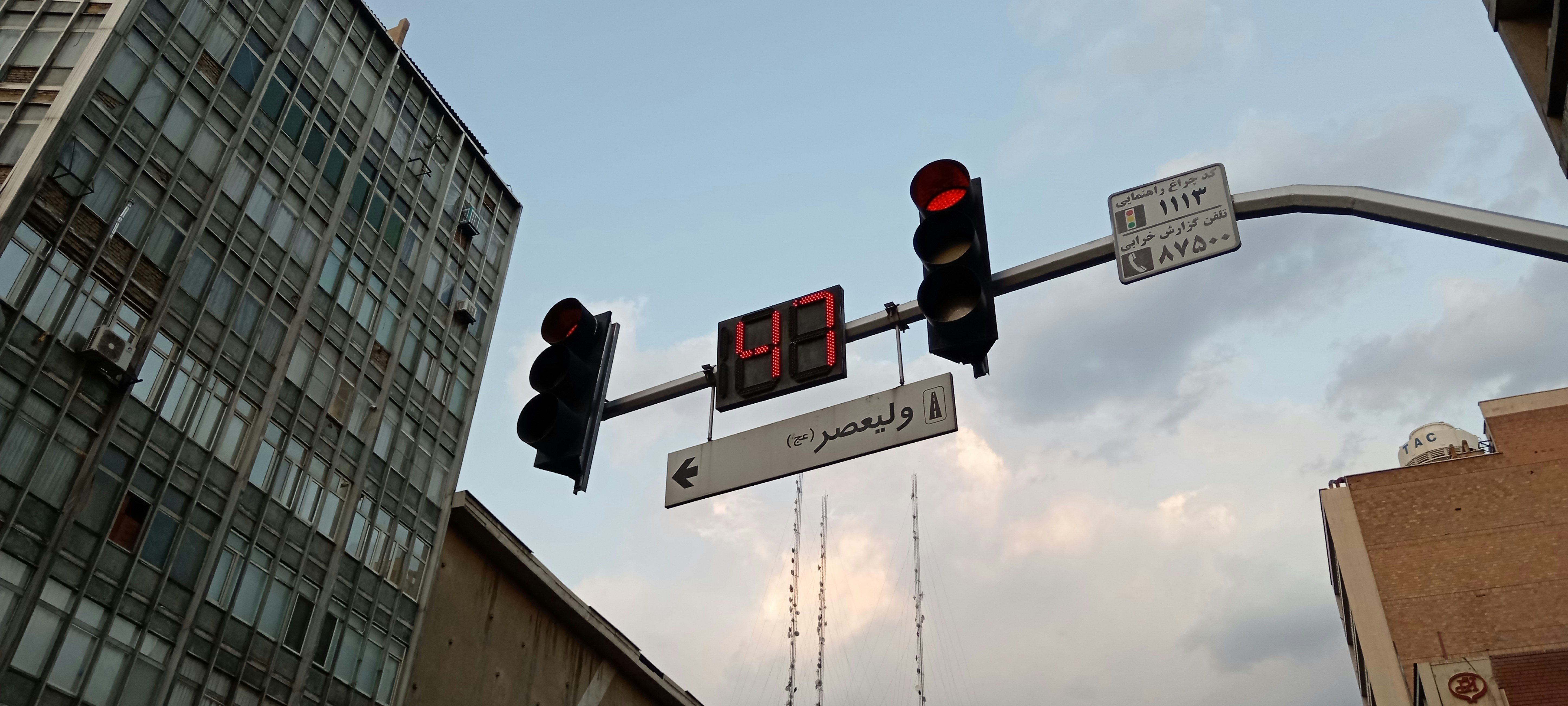 A traffic light hanging over a street next to tall buildings photo ...