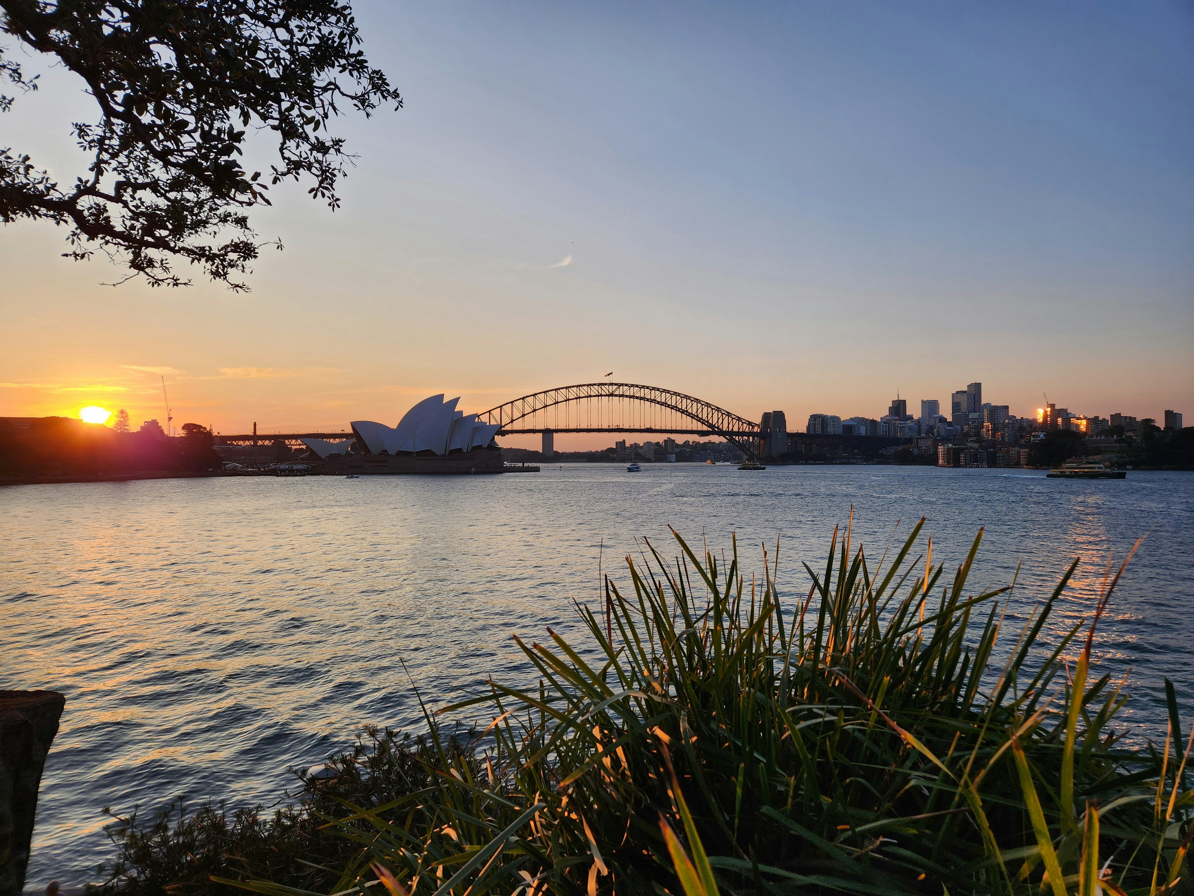 The sun is setting over the water with a bridge in the backgroundDominic Kurniawan Suryaputra