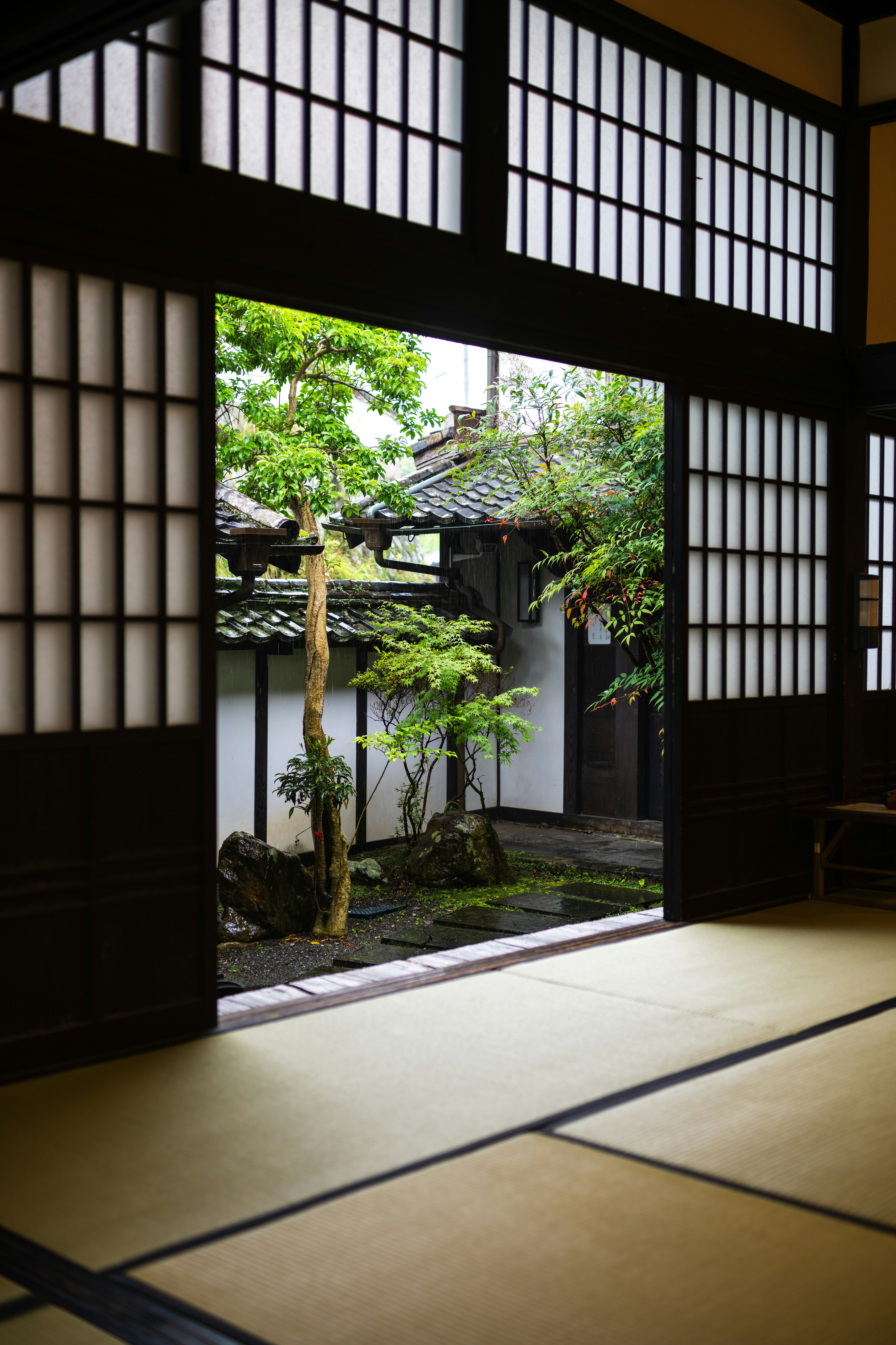 A room with a large open door leading to a garden photo – Free Image on ...