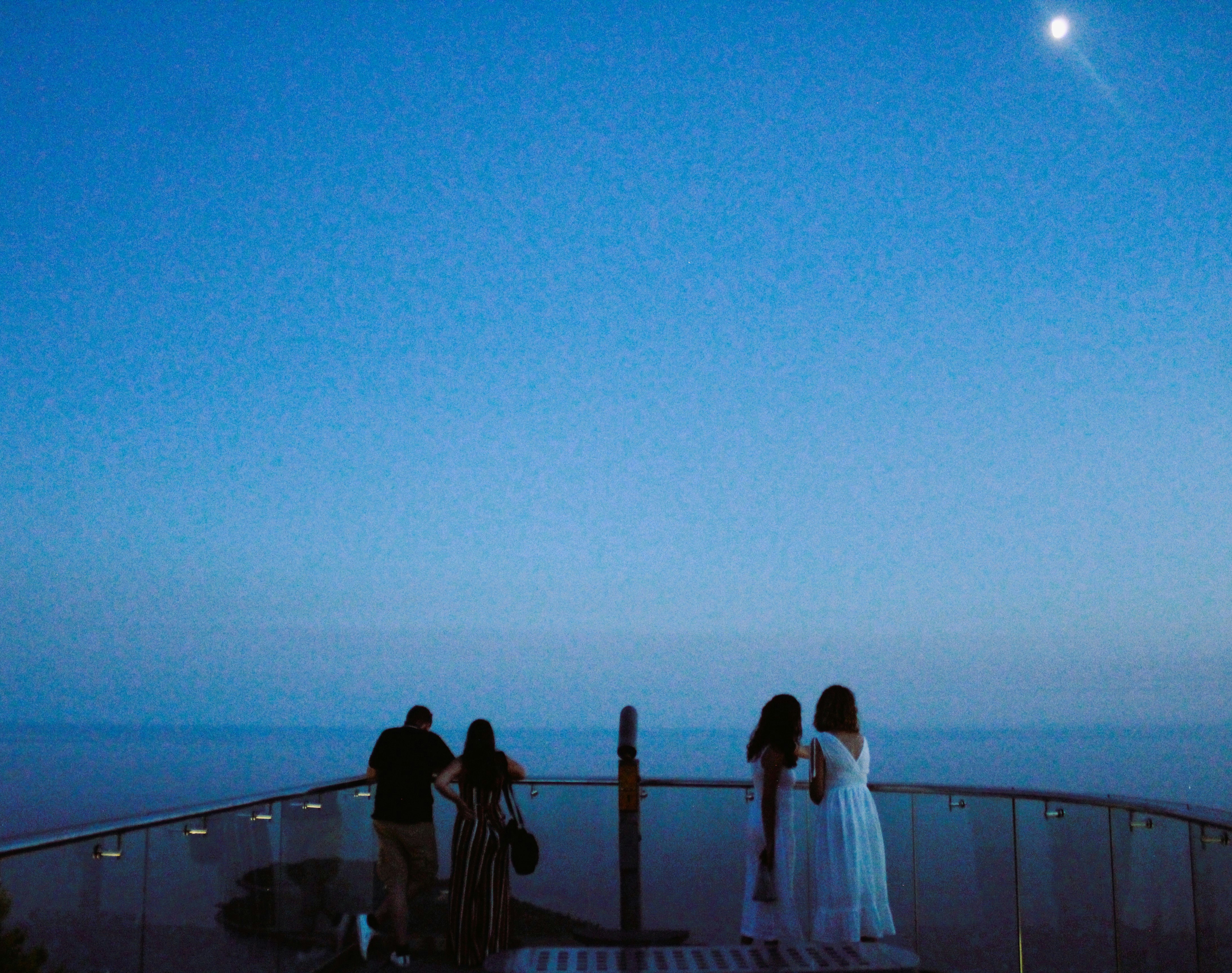 Moonlit Glass-Edge: silhouettes on a sea-facing terrace