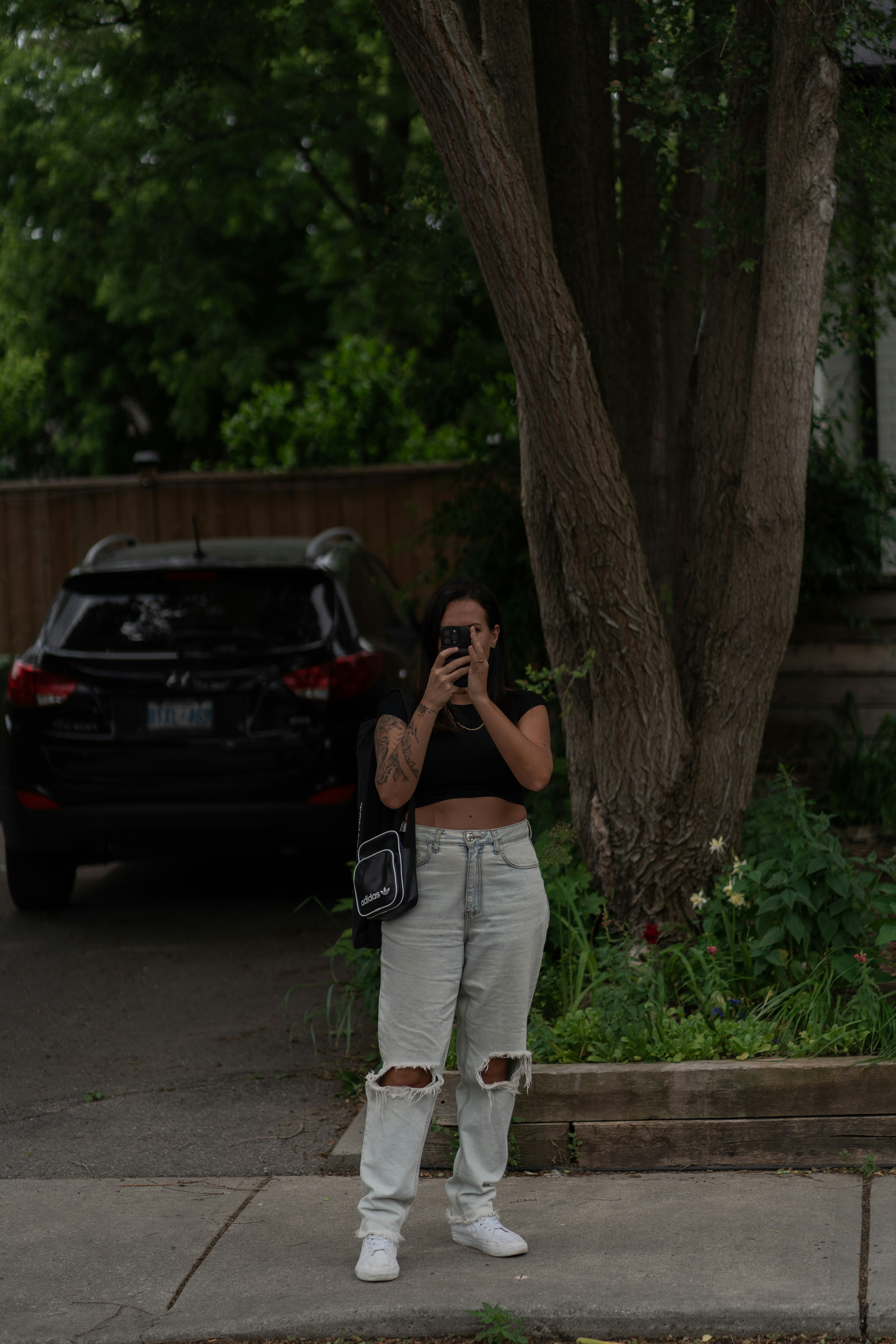 Selfie in the Shade: Street Portrait with Car Backdrop and Greenery