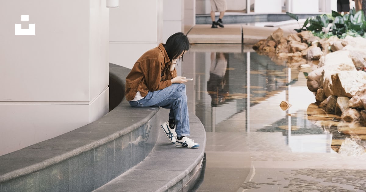 건물의 난간에 앉아 있는 사람 사진 Unsplash의 무료 이미지