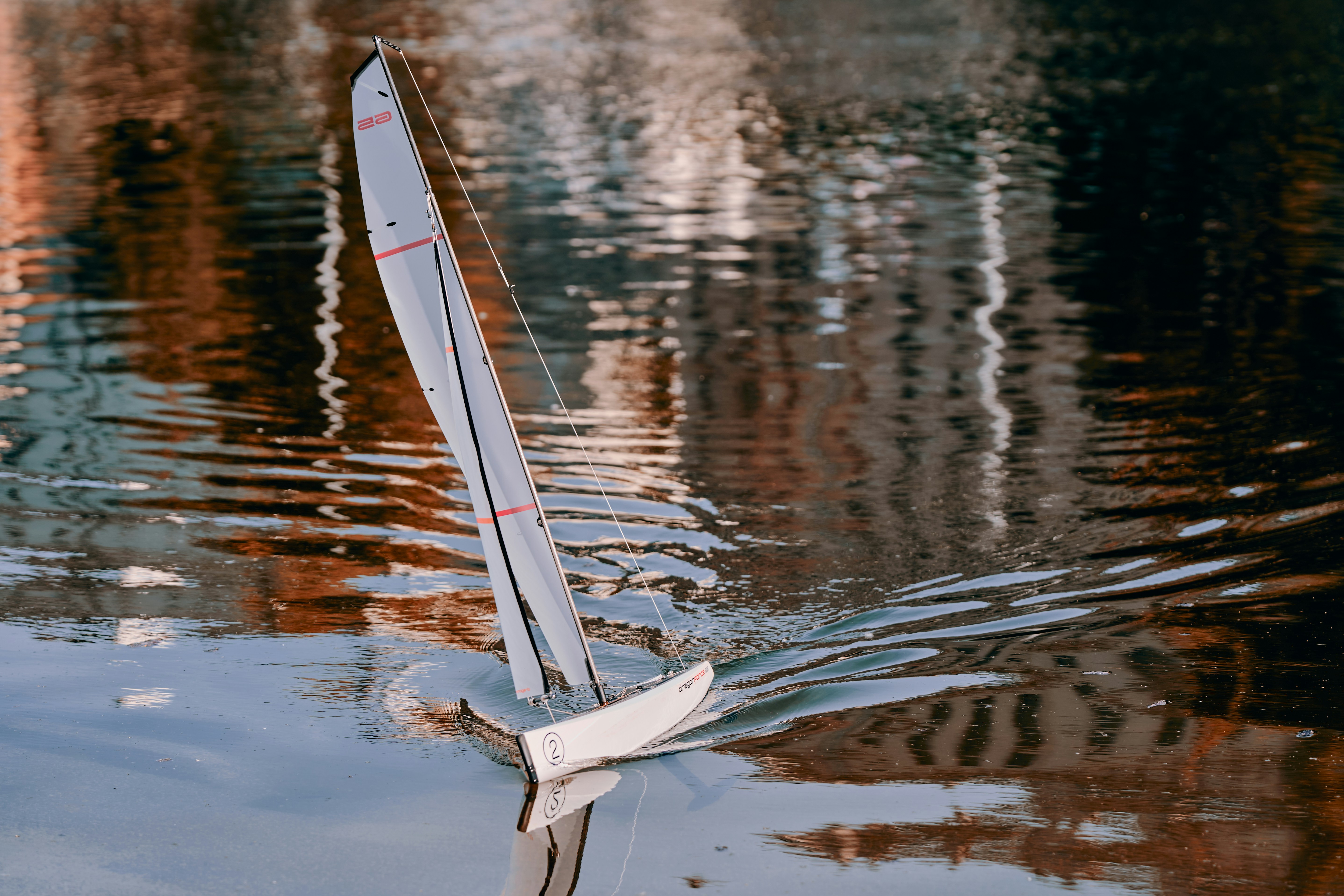 Miniature Sailboat on a Sunset-Glazed Mirror of Water