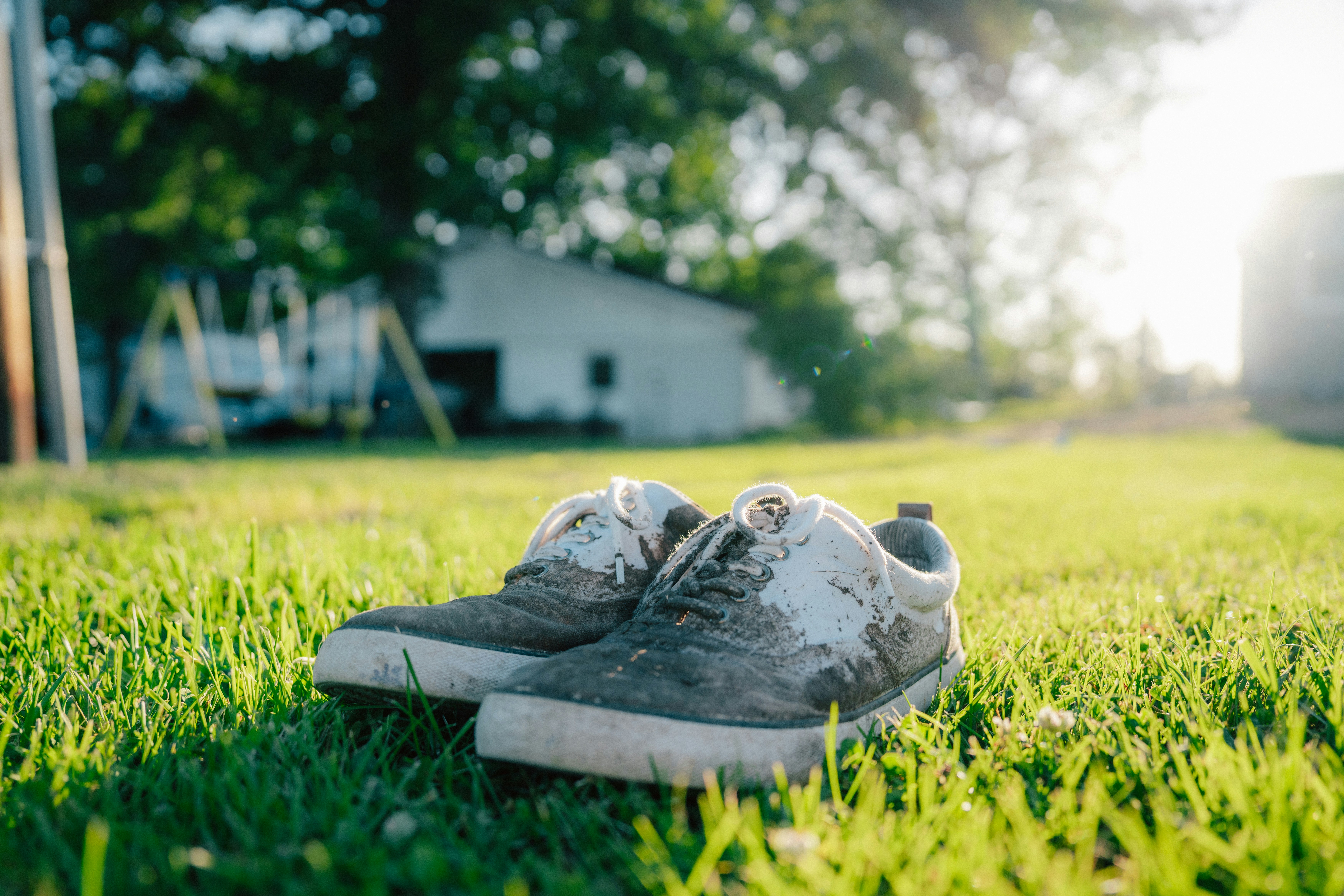 Worn Sneakers Rest on Sunlit Grass