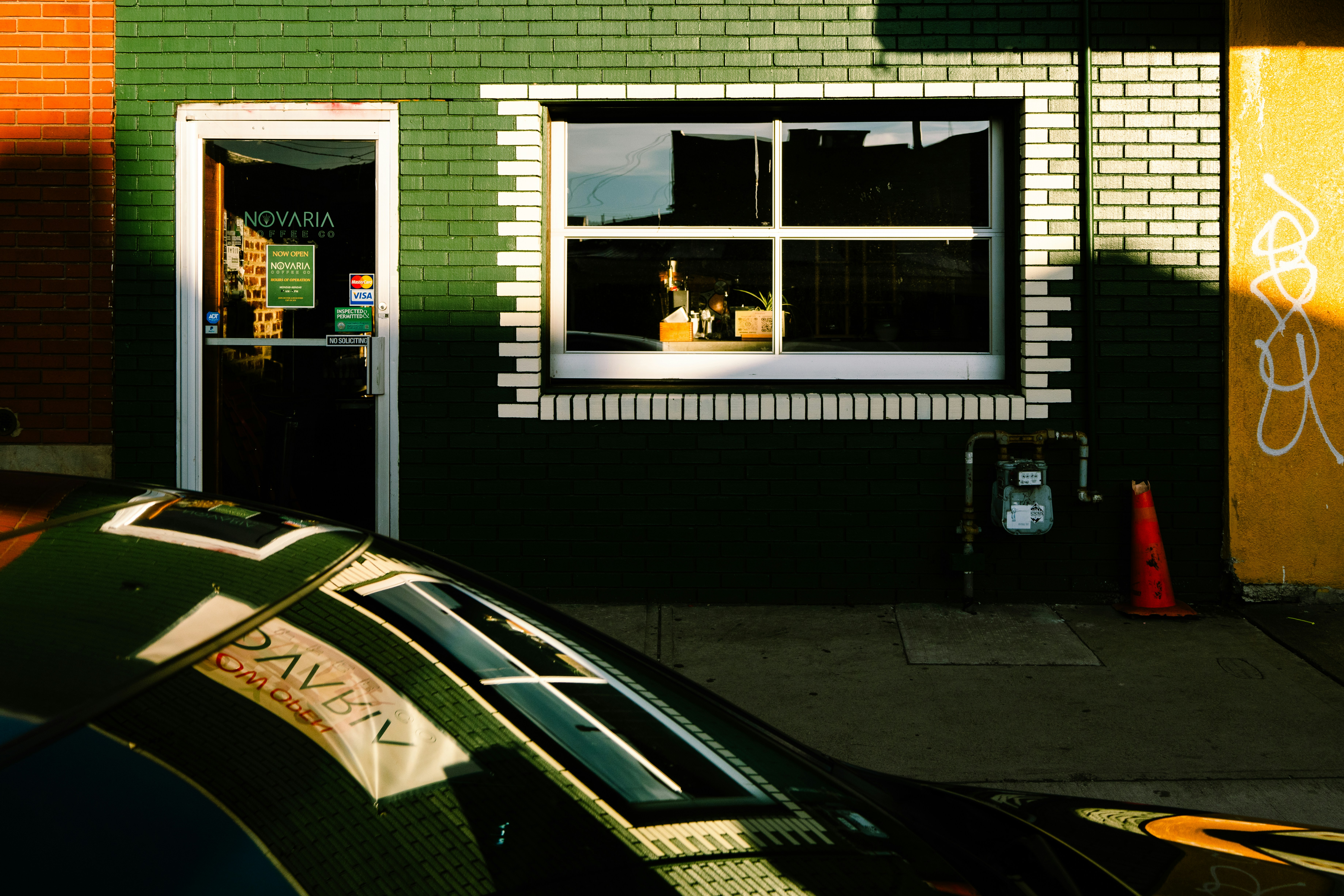Windowed Light on a Green Brick Facade: An Urban Quiet Portrait