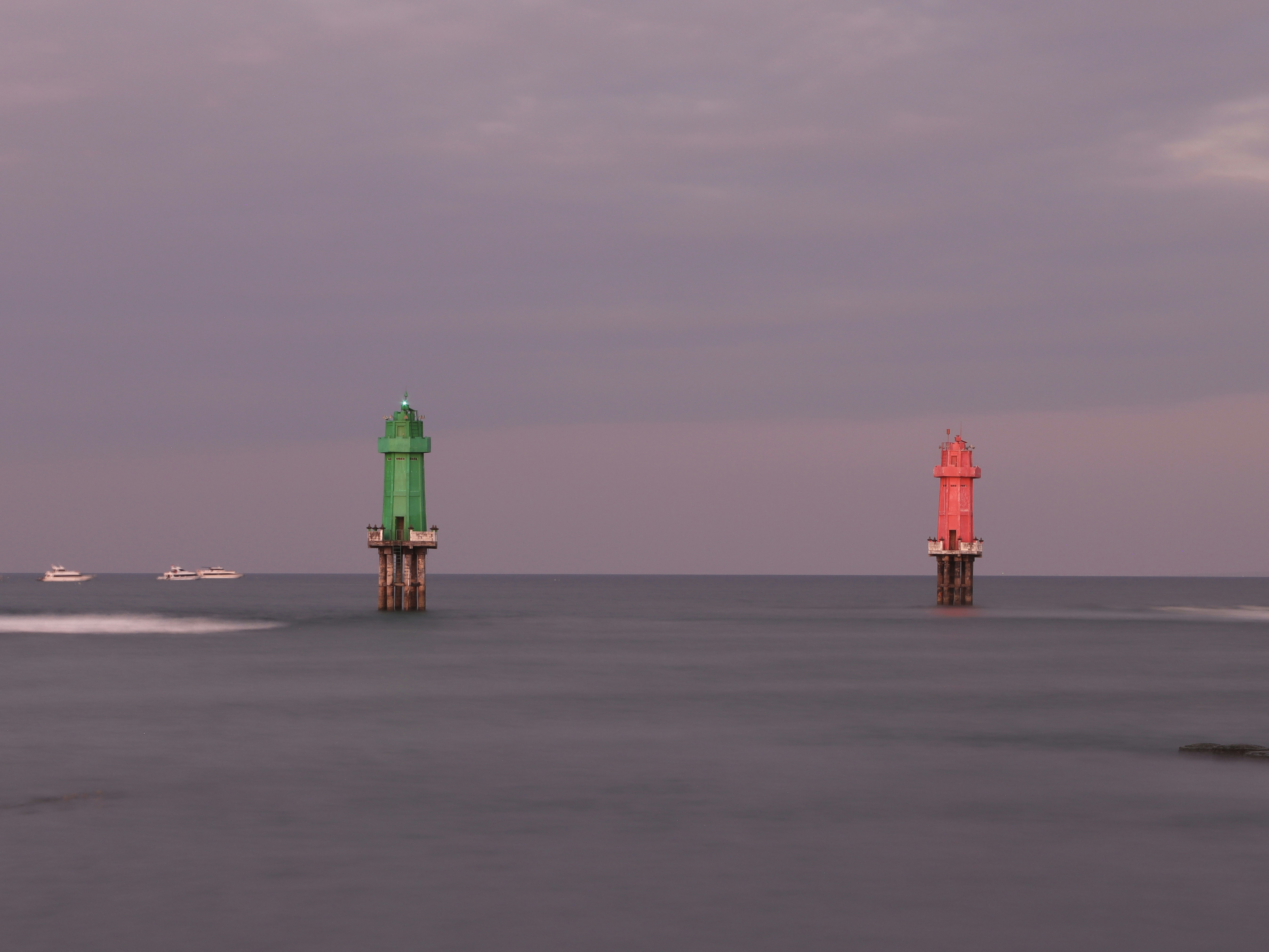 Dusk Beacons: Green and Red Lighthouses Rising from a Violet Sea